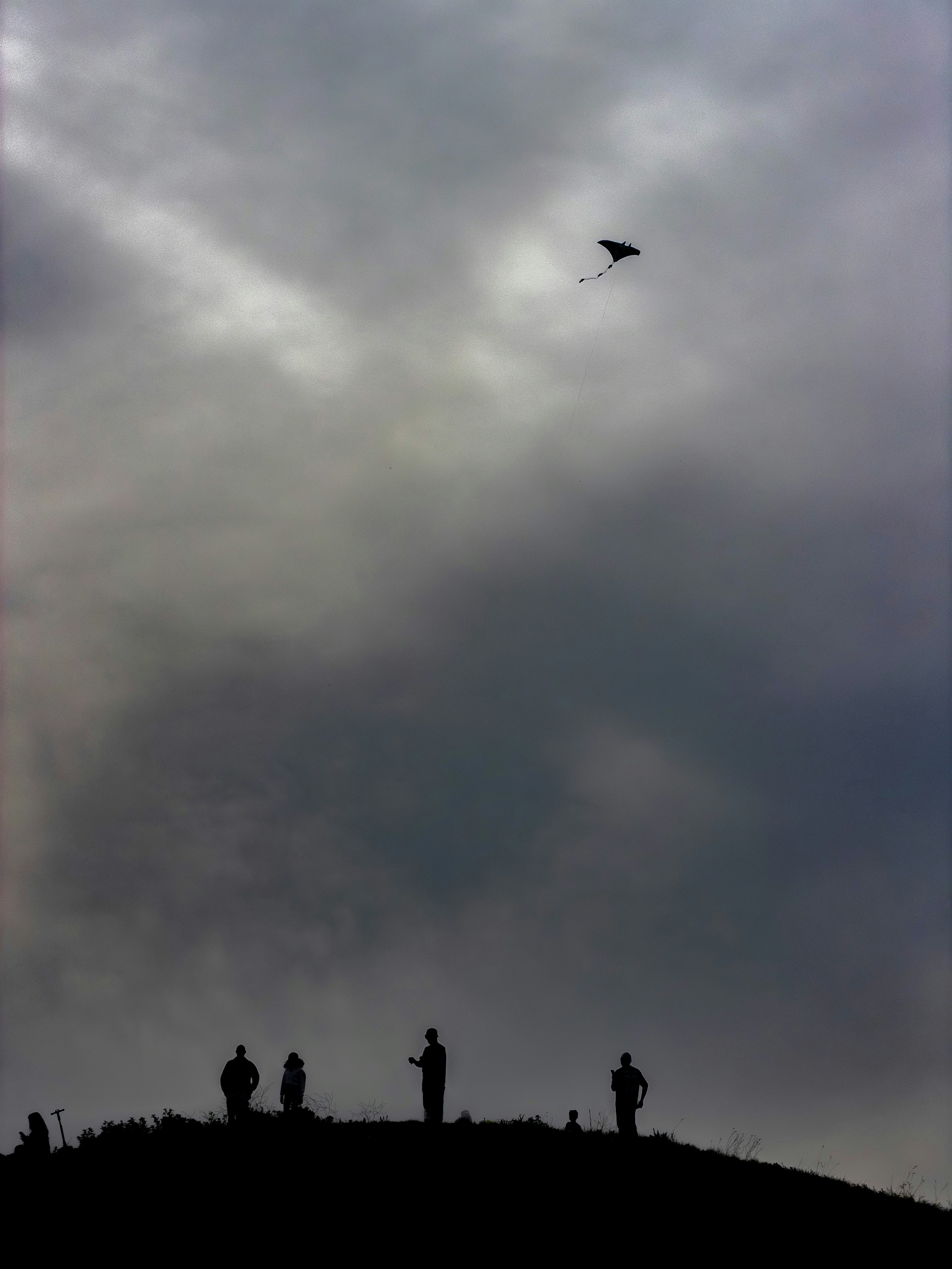 Silhouette on the Ridge: A Lone Kite Under An Expansive Sky