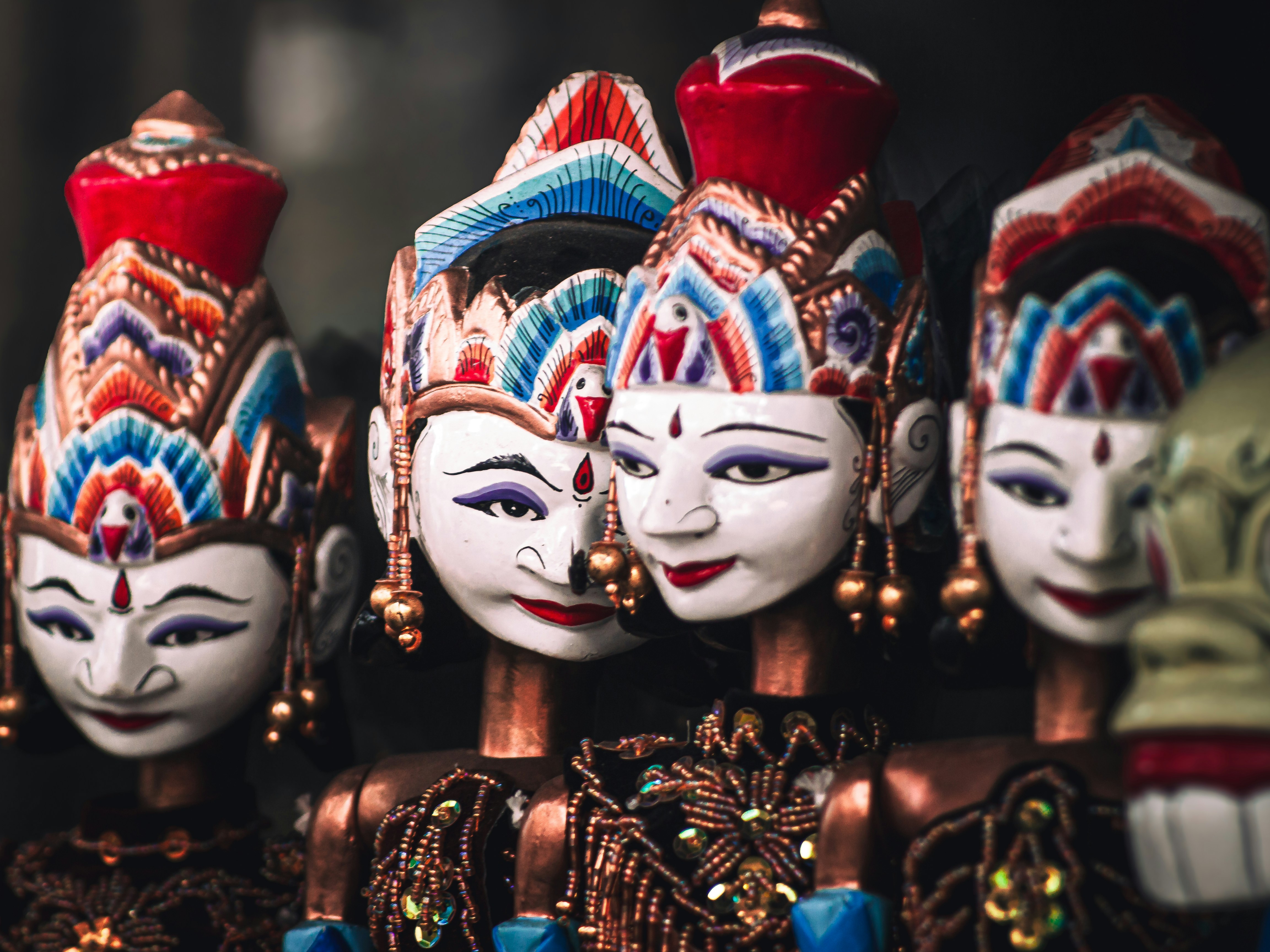 Masked Harmony: Faces in a Row of Colorful Carved Statues