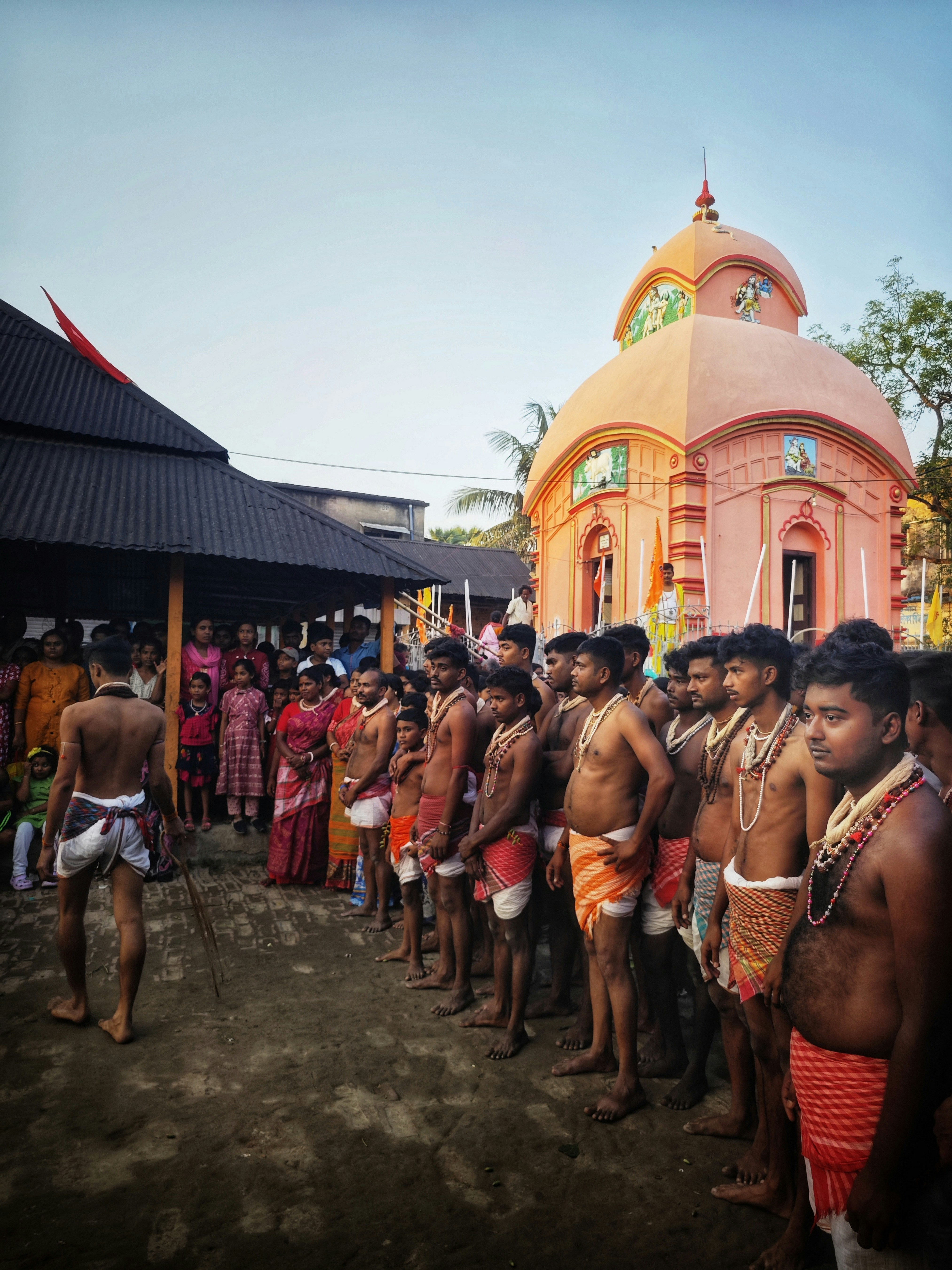 Men in traditional attire gathered near a temple