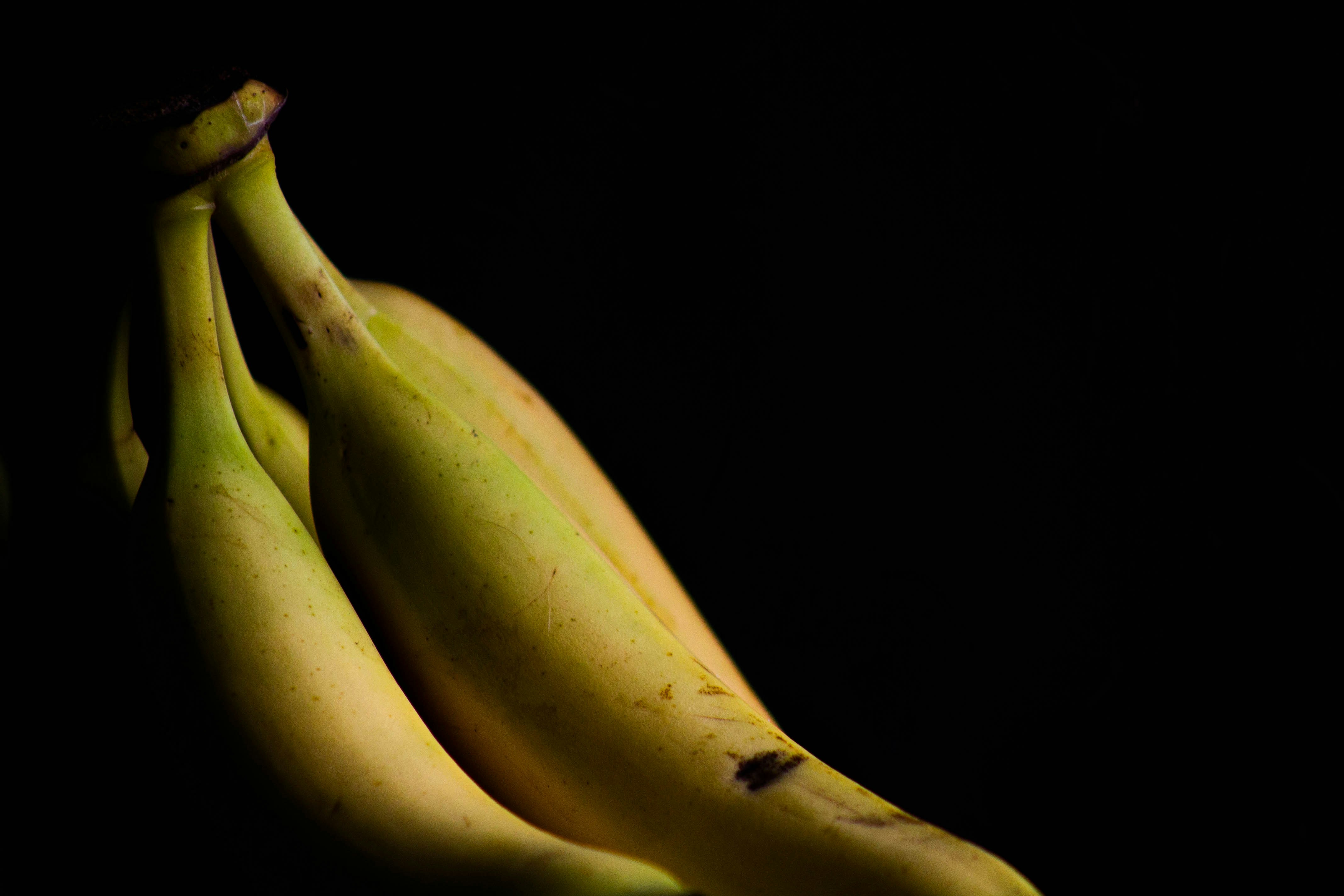 Moonlit Banana Trio: A Slender Silhouette against Darkness