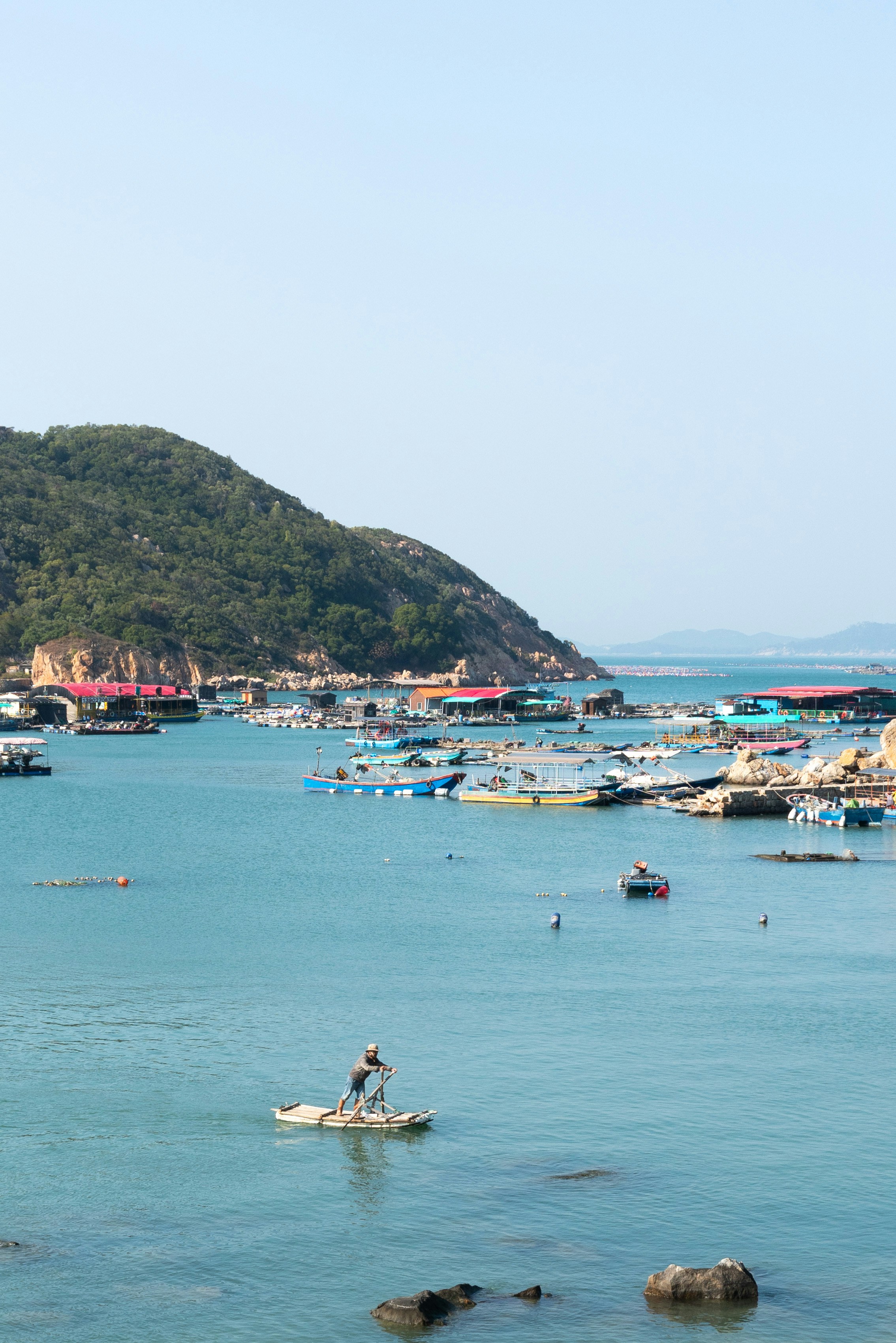 Harbor Quiet: A Small Boat Drifts Near a Sunny Coastline