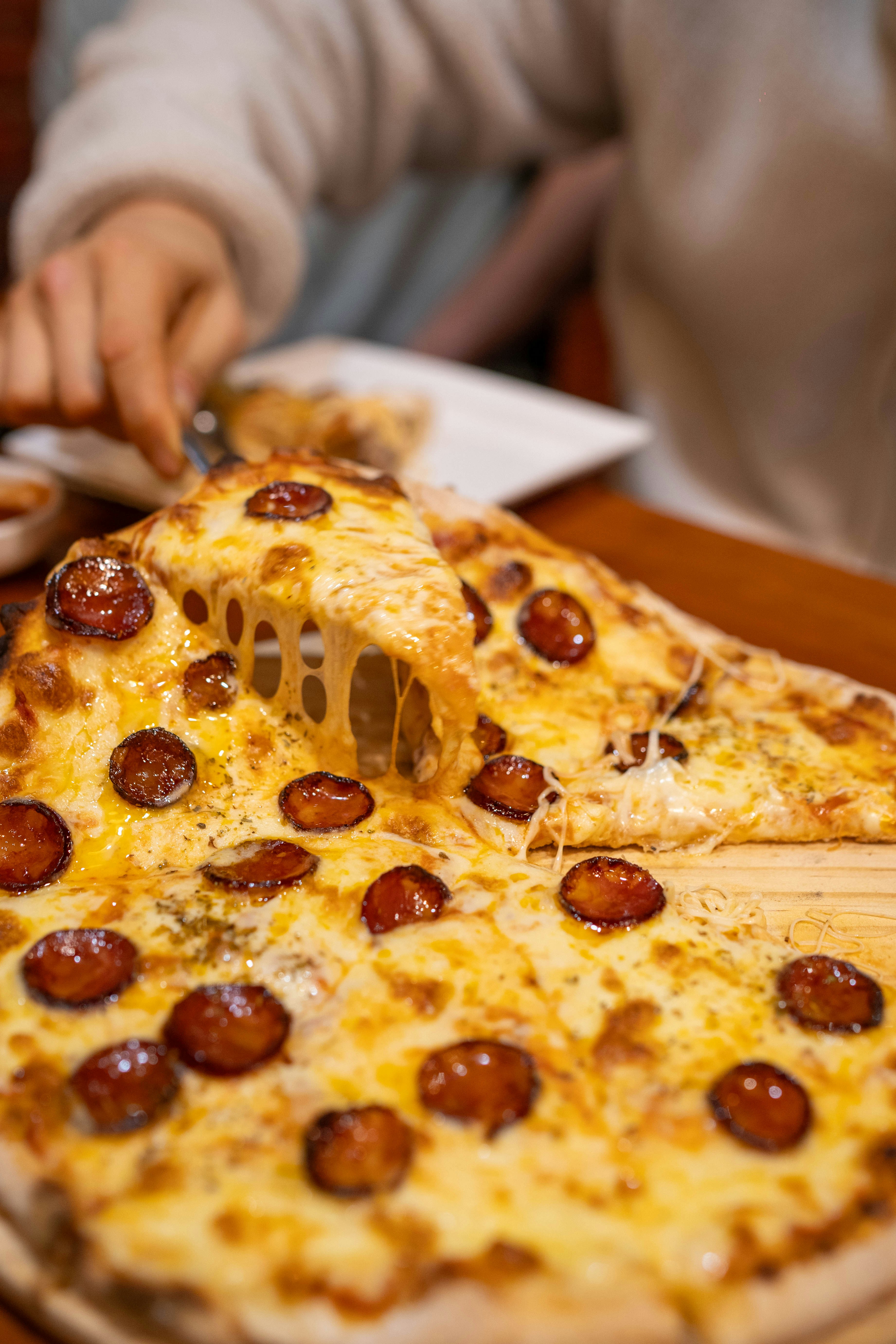 Stretch of melted cheese over a pepperoni pizza slice being lifted