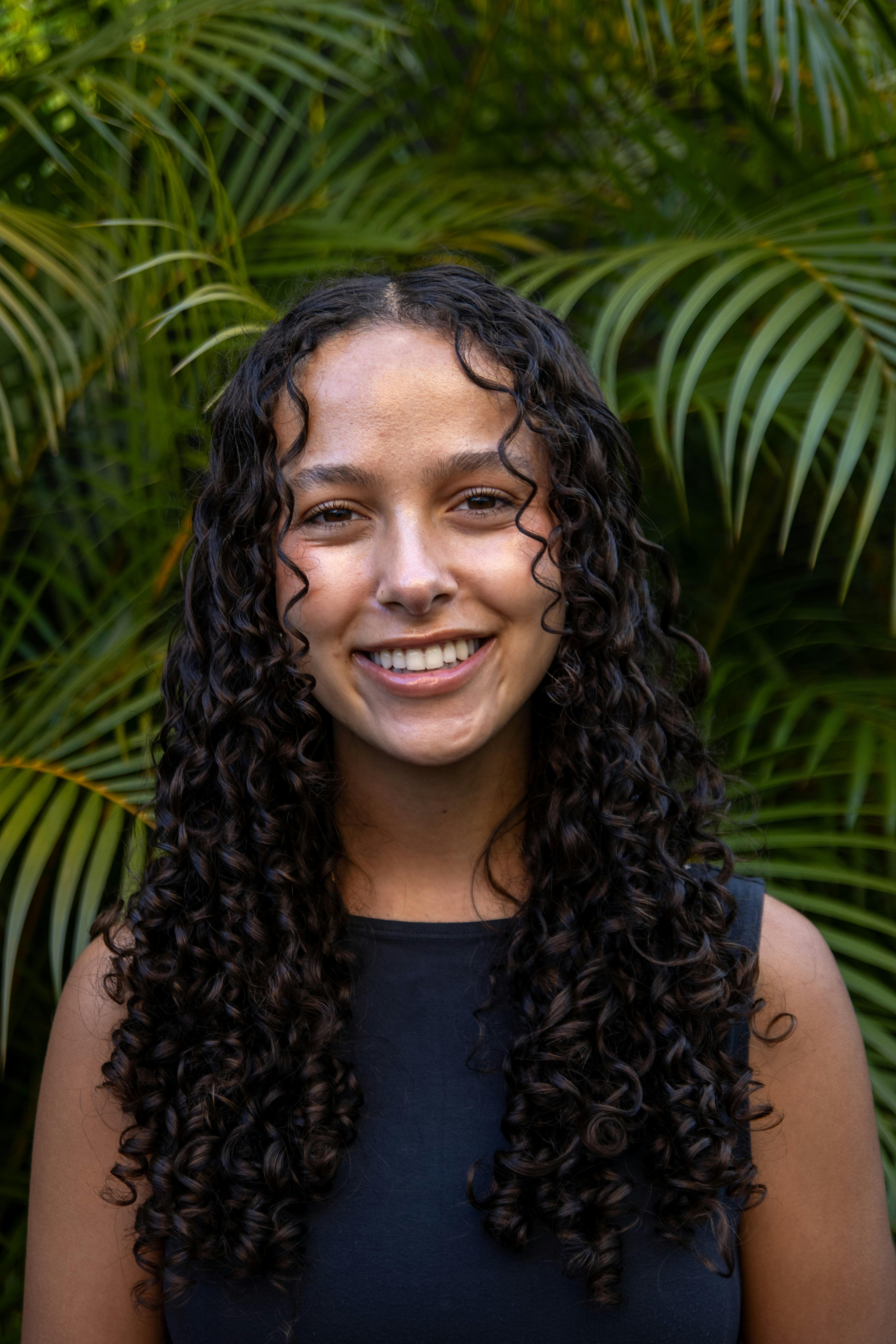Curly Portrait Beneath Green Fronds