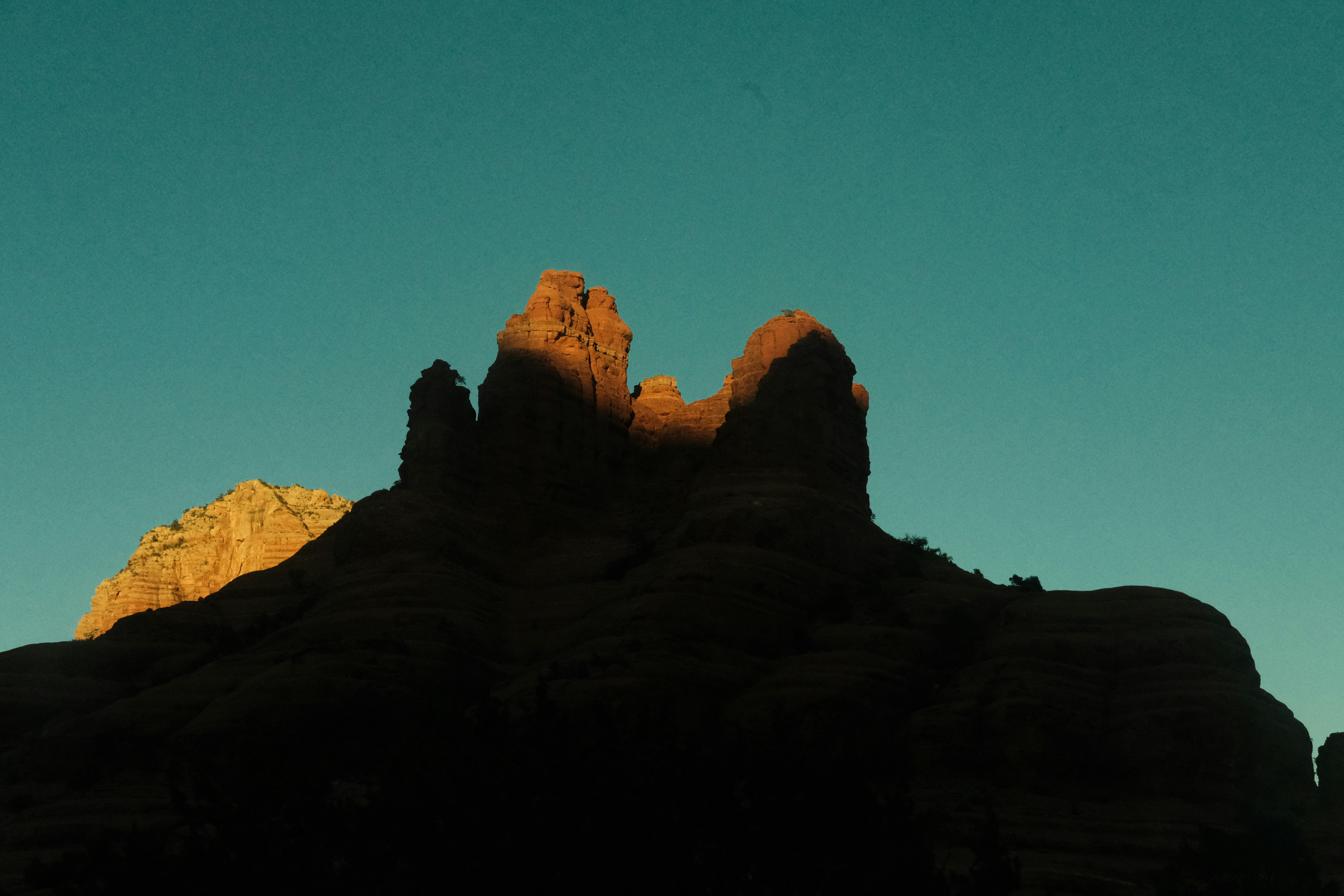 Sunlit Sentinel: A Dim Ridge Crowned by Golden Stone