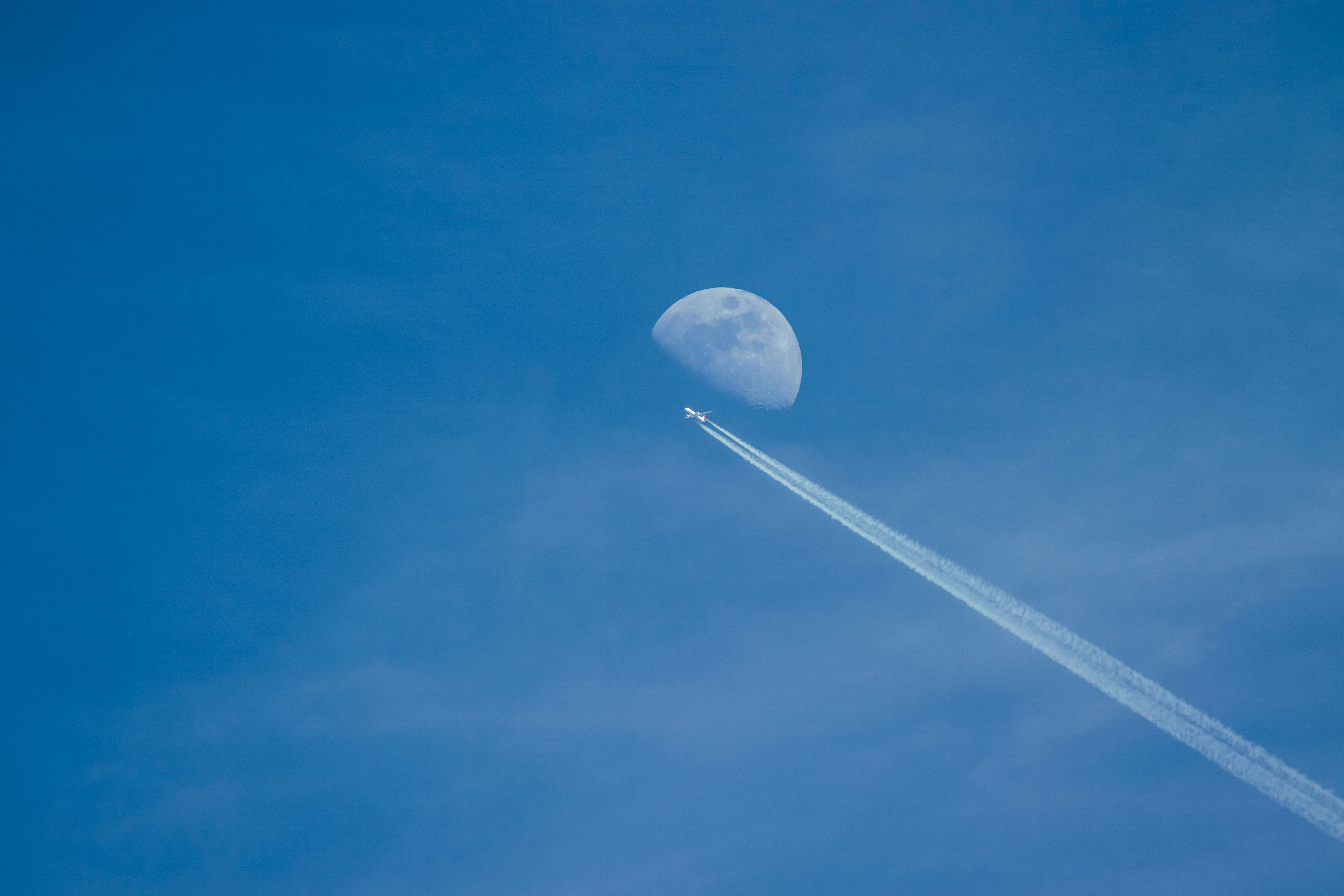 Moon Crescent Tracked by a Jet: A Skyward Contrail Moment
