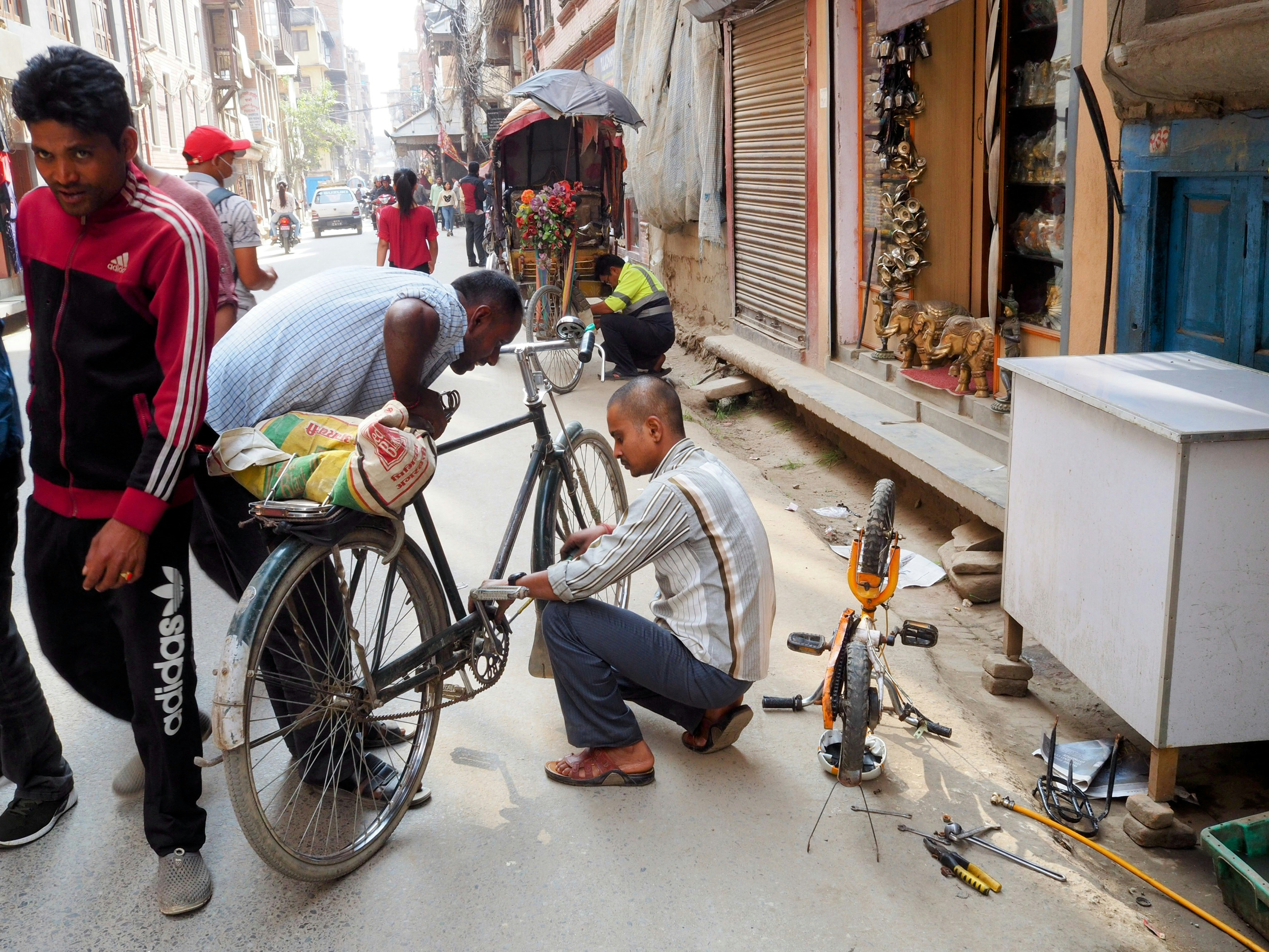 Repair in the Alley: A Fixer Tightens a Neighbor’s Bicycle