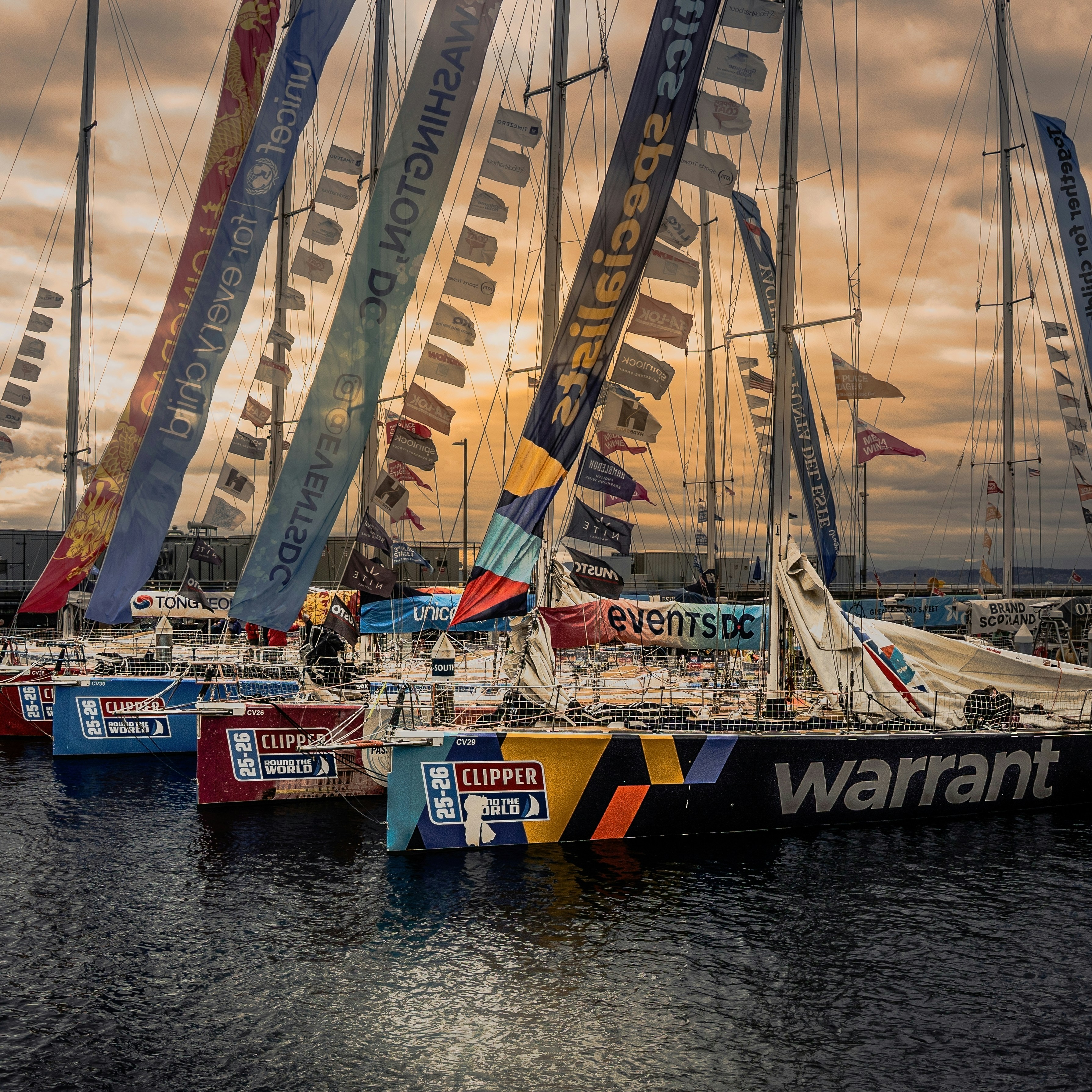 Fleet of Sails at Dusk: Corporate Race Boats Rest on the Calm Water
