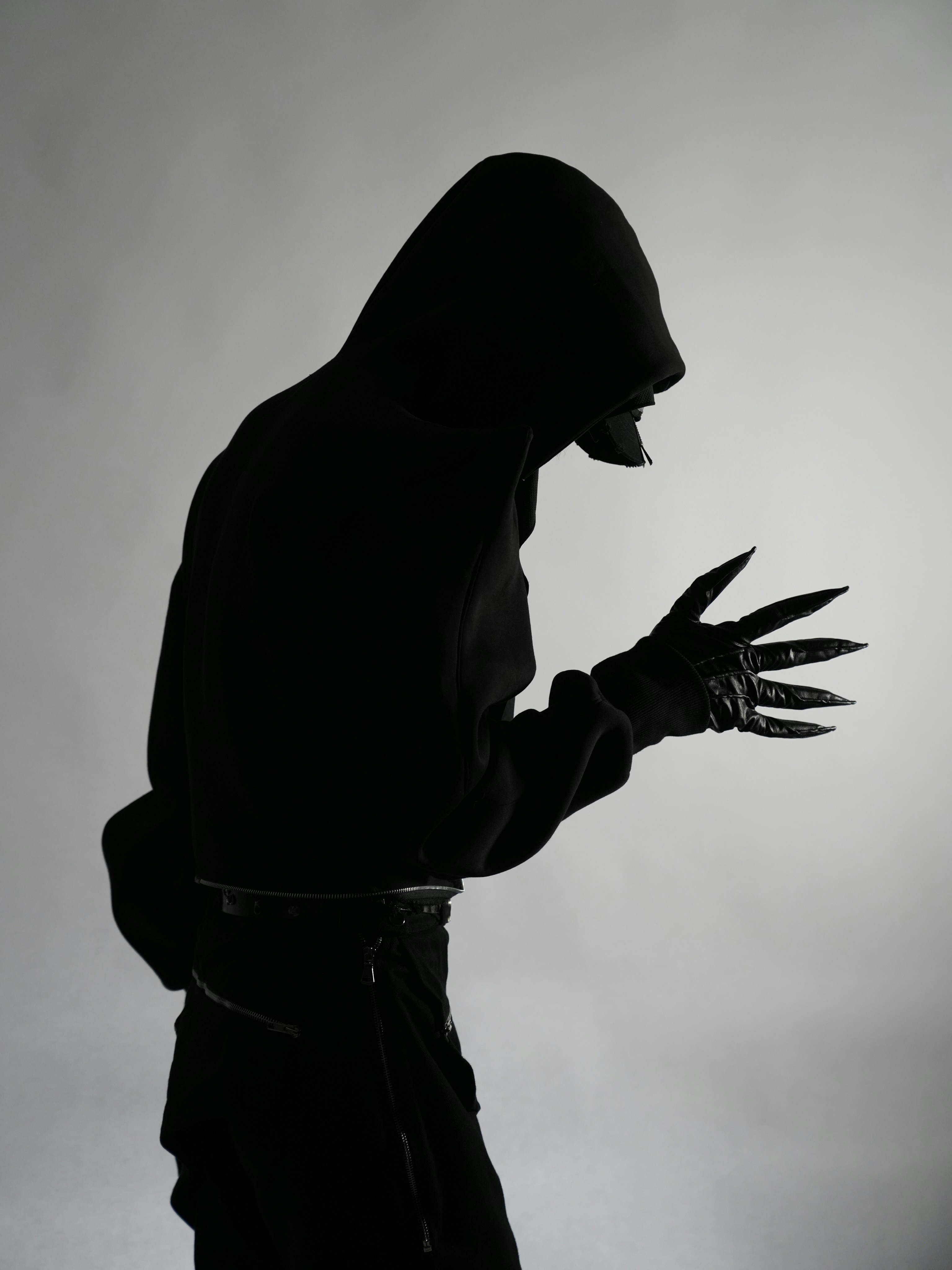 Shadowed Reaper: A Hooded Figure unfurls a skeletal hand in monochrome mystery