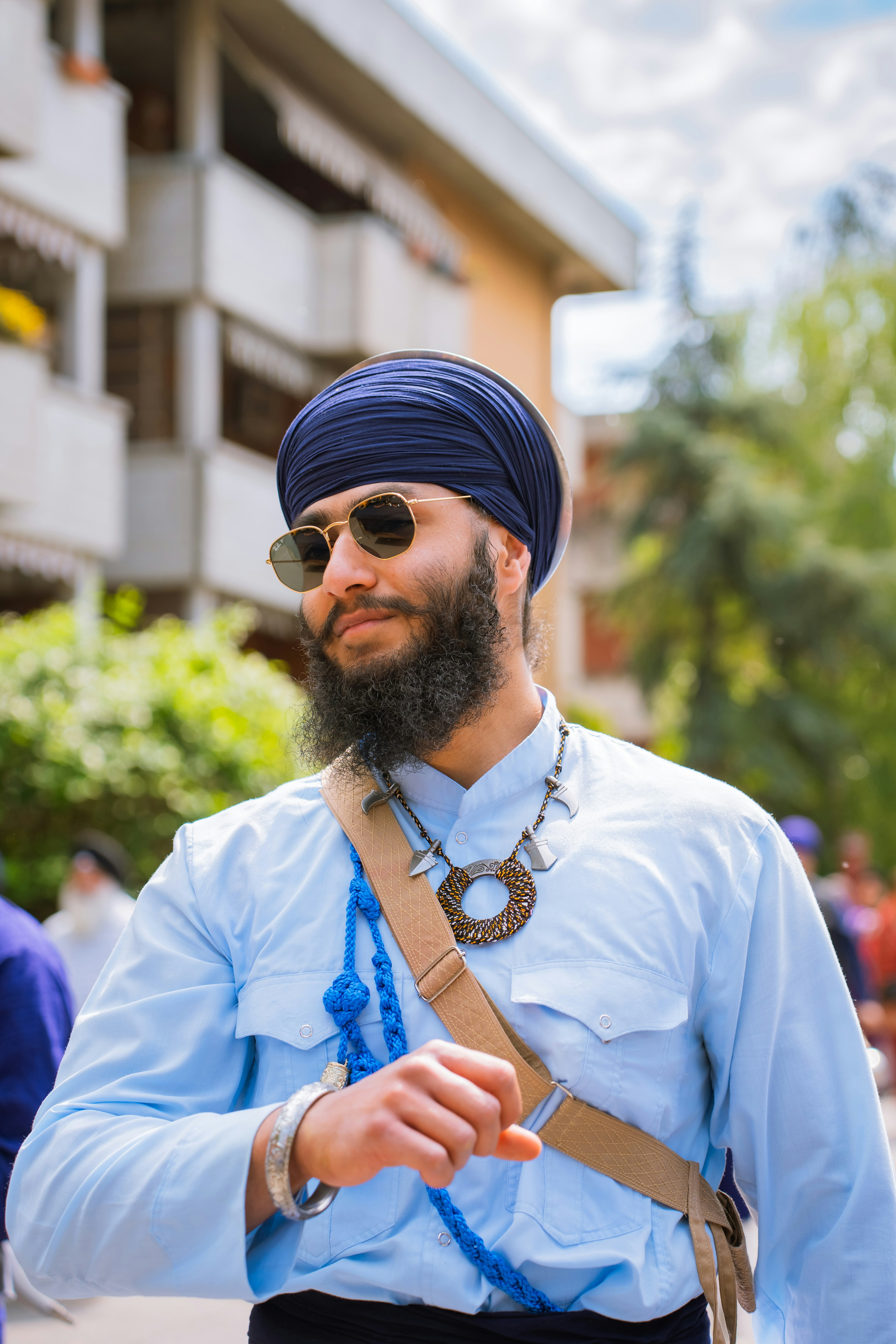 Bearded Voyager in Blue: A Turbaned Portrait Amid City Light