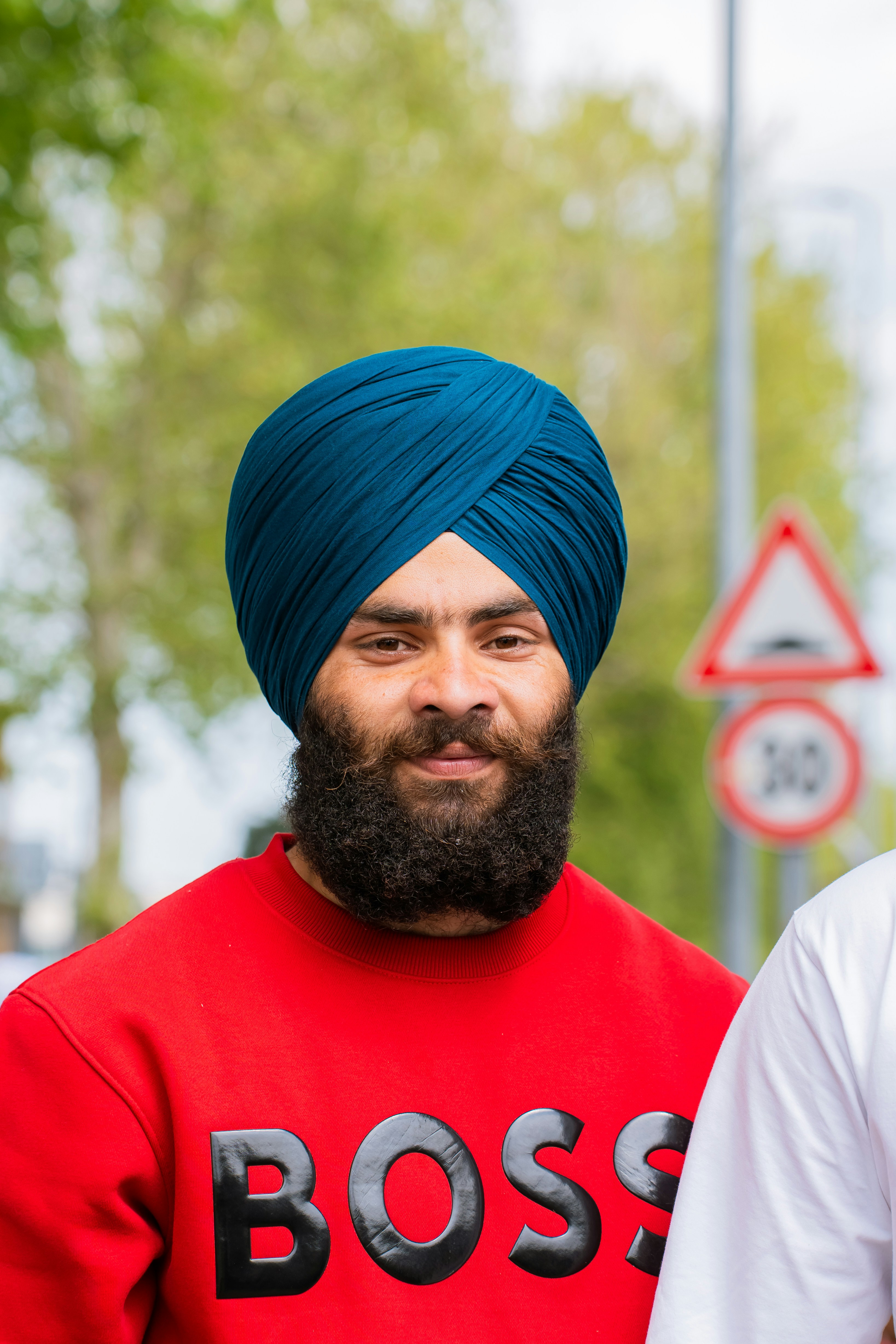 Blue Turban, Bold Smile: A Street Portrait in Red