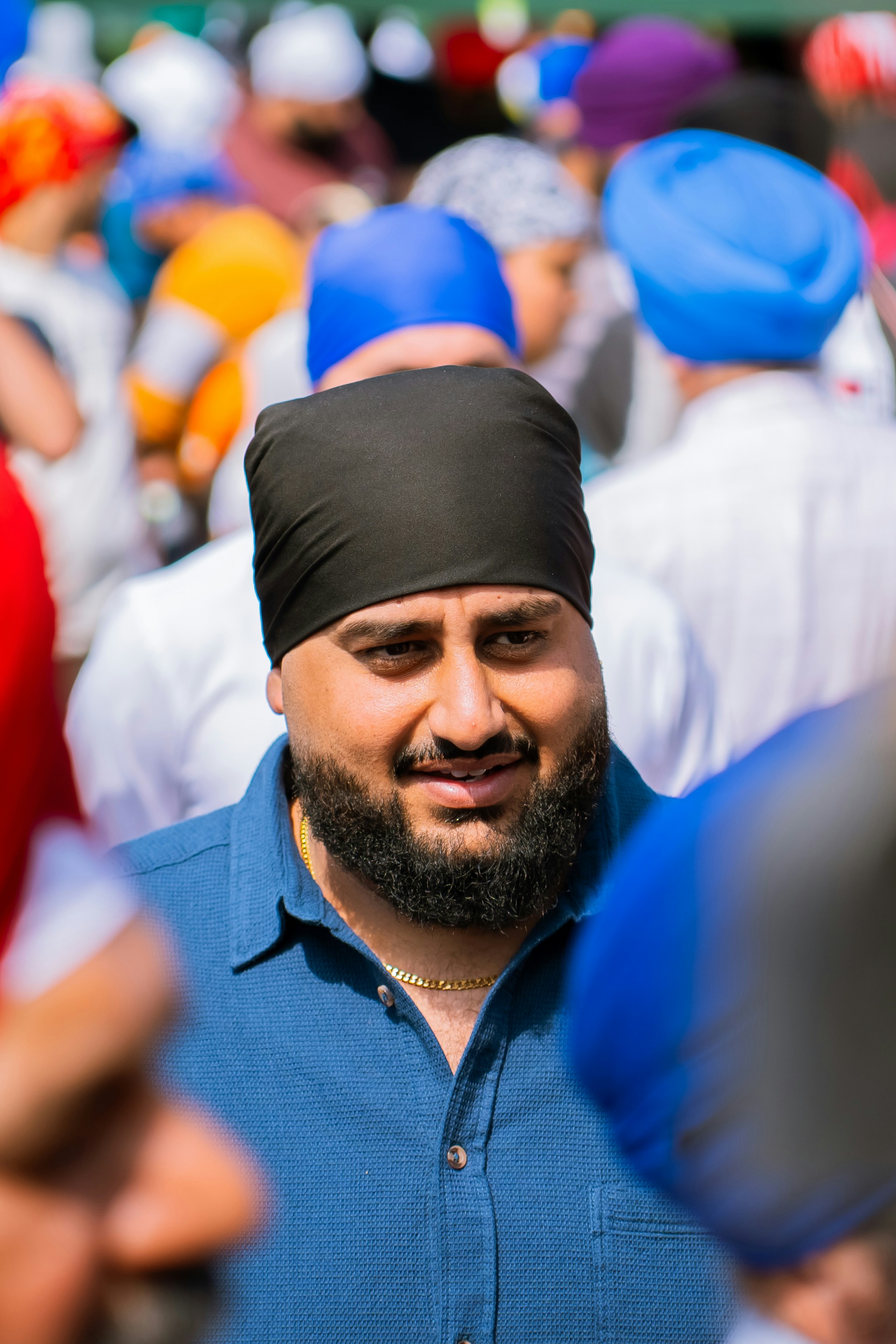 Bearded man in turban amid a colorful crowd