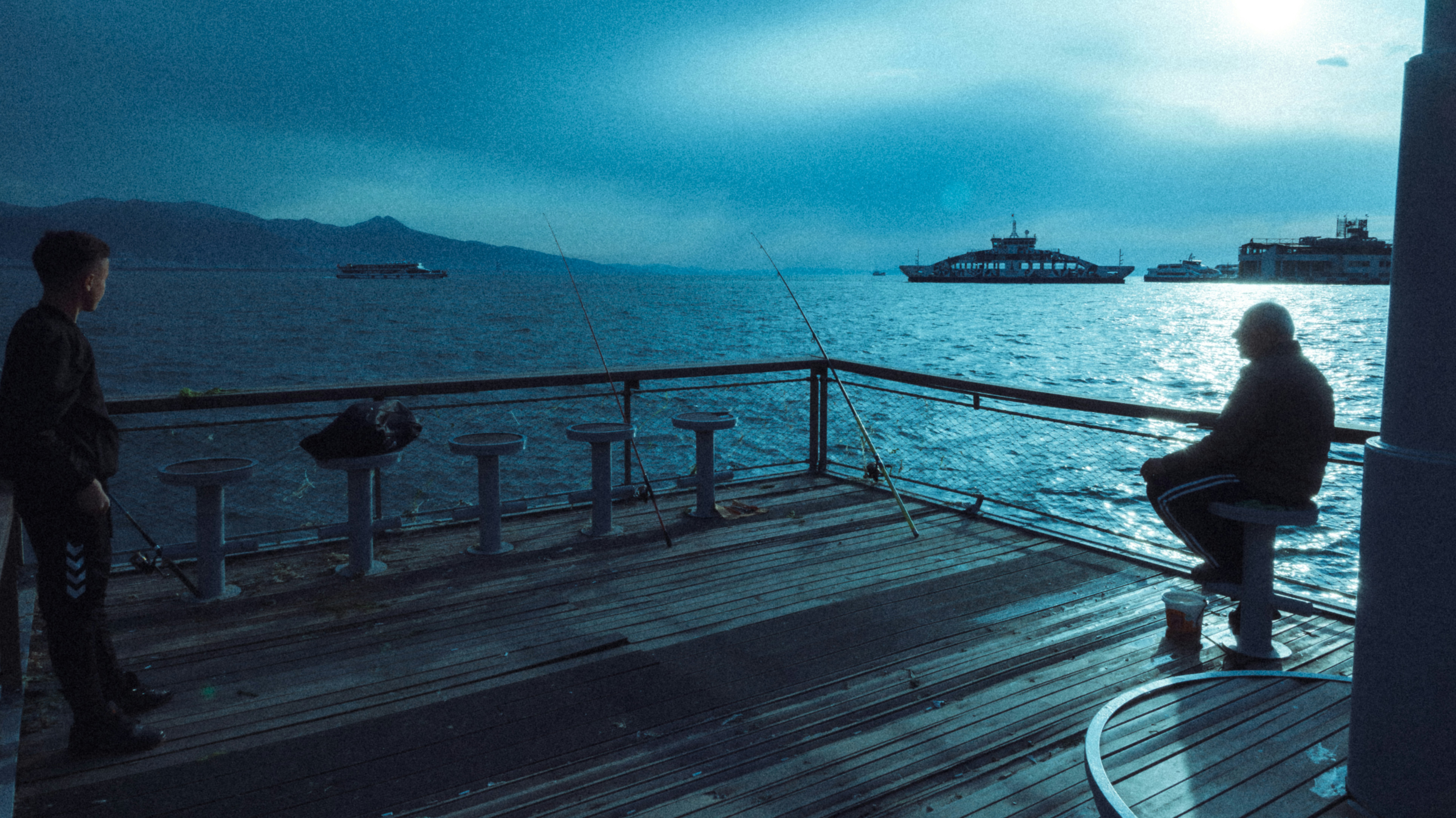 Quiet Exchange: A Seafront Moment on a Dusk-Washed Pier