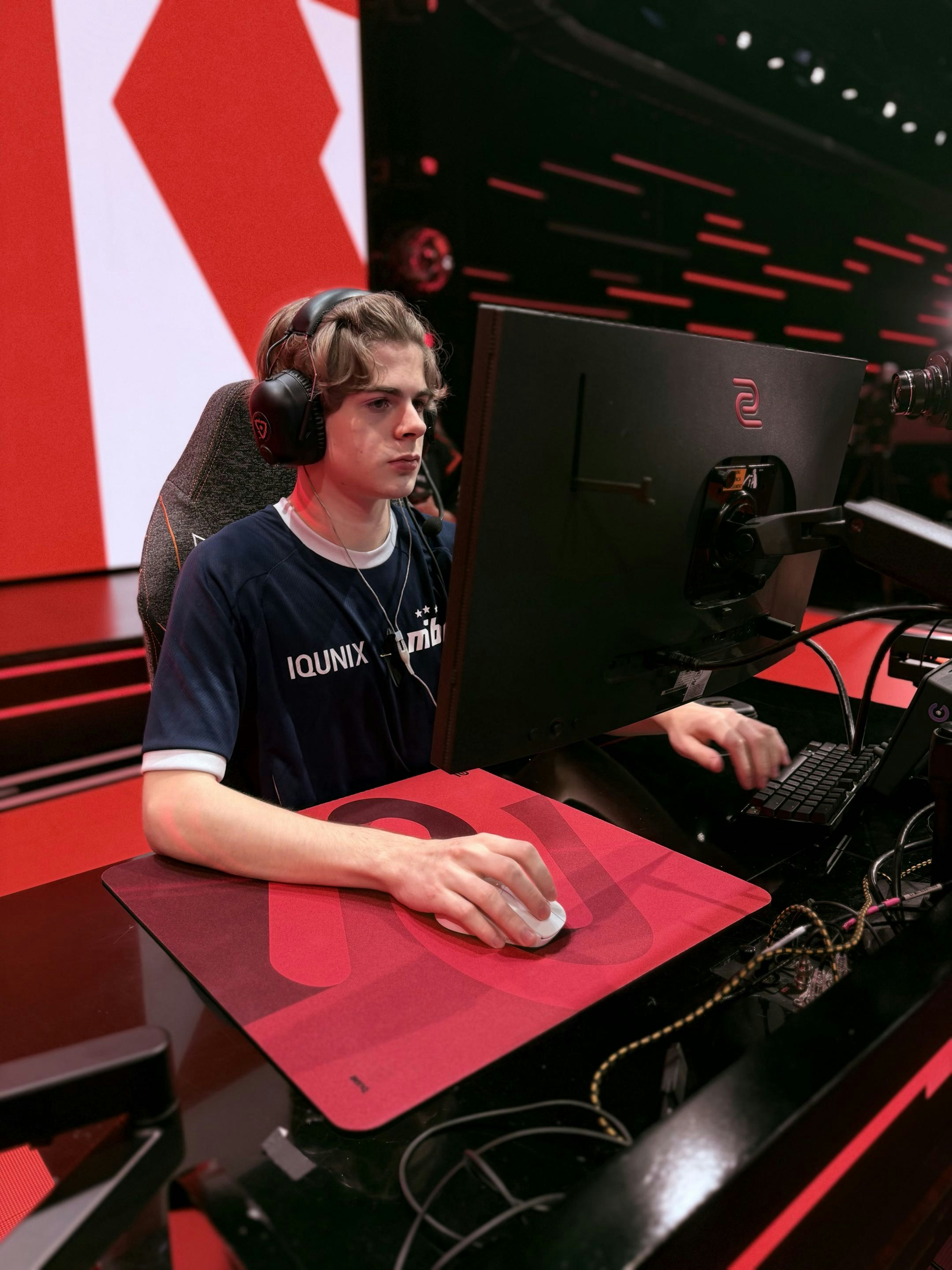Focused Gamer: Neon-lit Desk, Concentrated Gamer in Red Studio