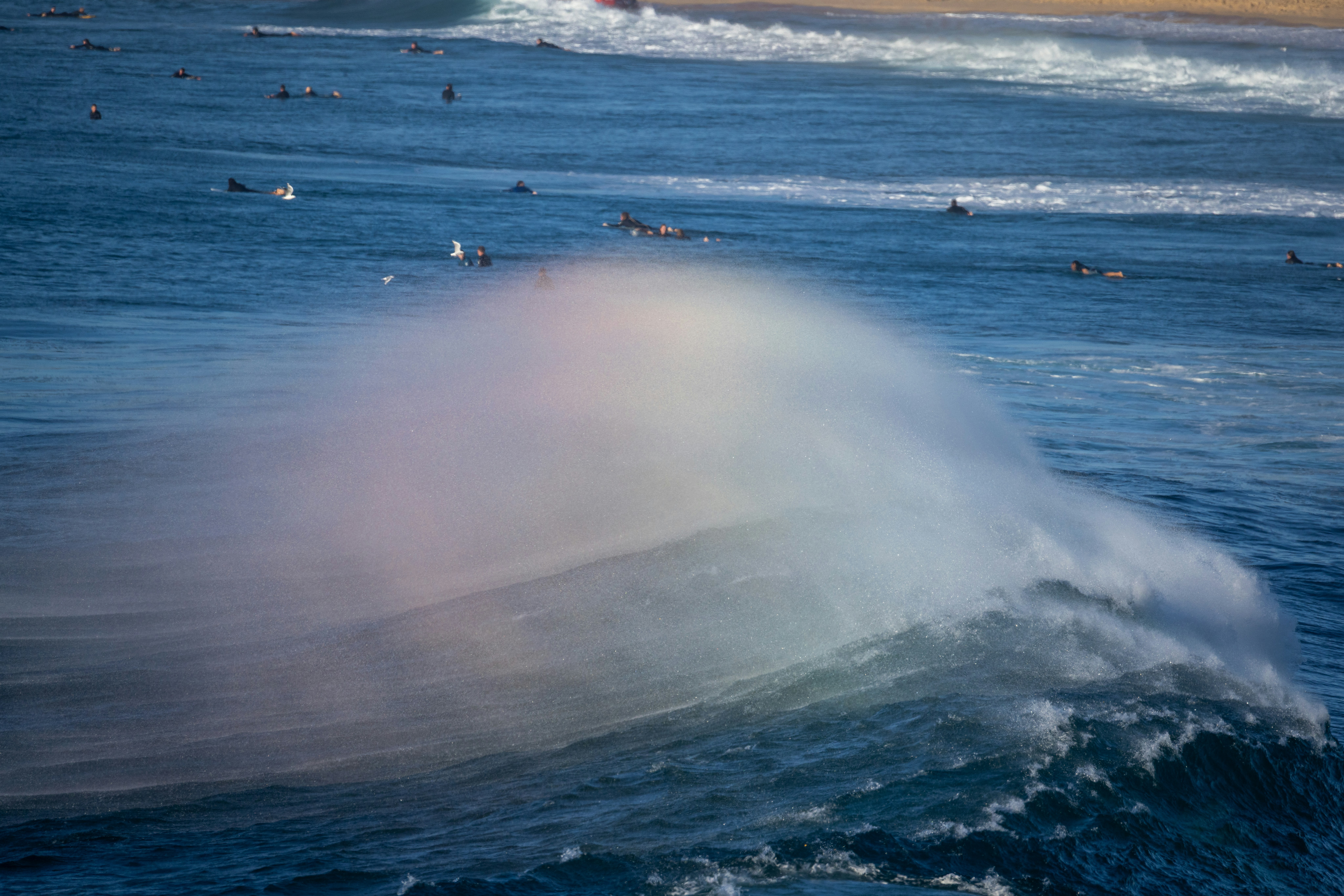 Jet of Rainbow-Crested Spray Engulfing a Rolling Wave