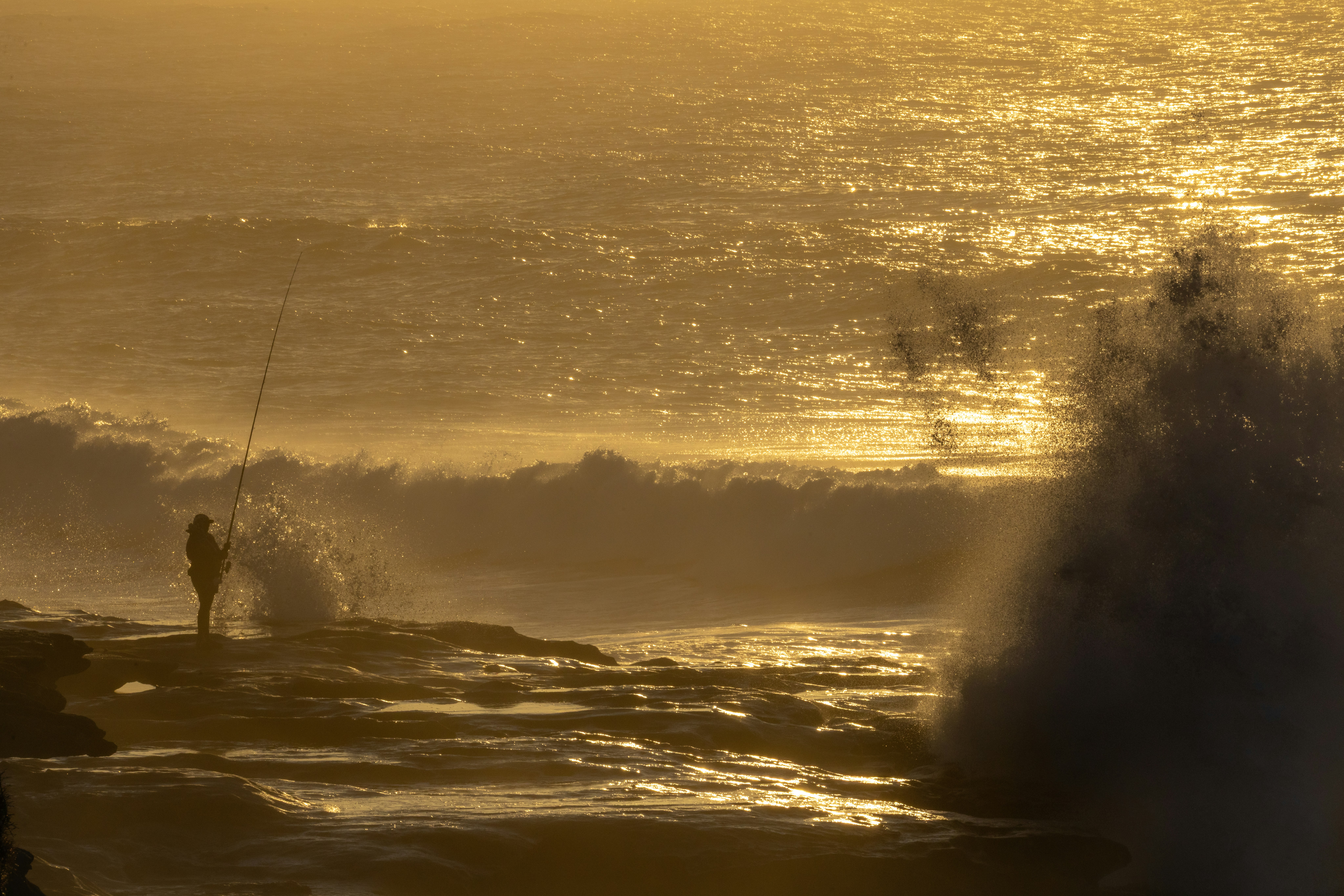 Salt Spray Silhouette: A Lone Angler Tames the Tidal Break