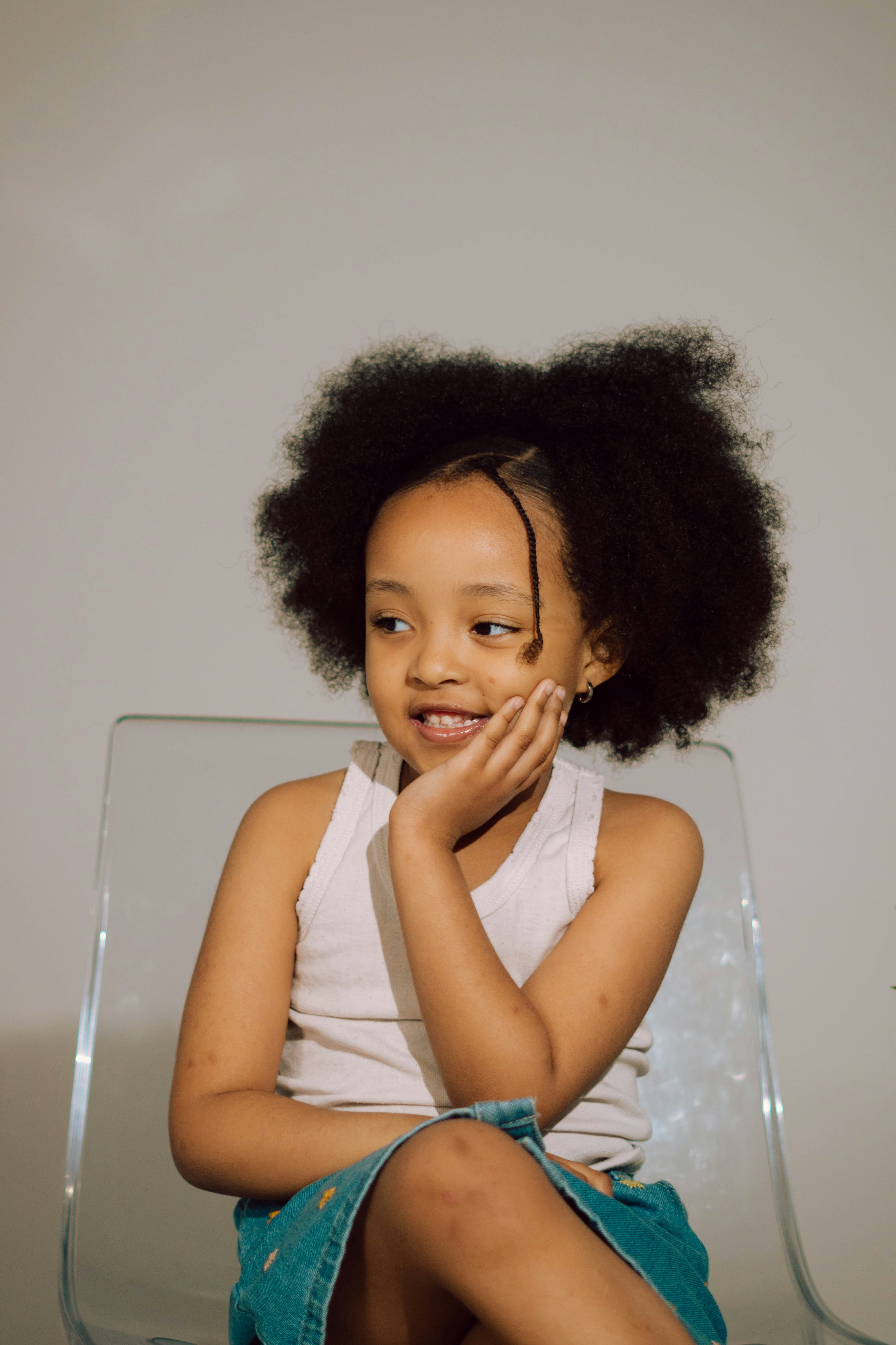 Childhood Curiosity: A Quiet Moment on the Transparent Chair
