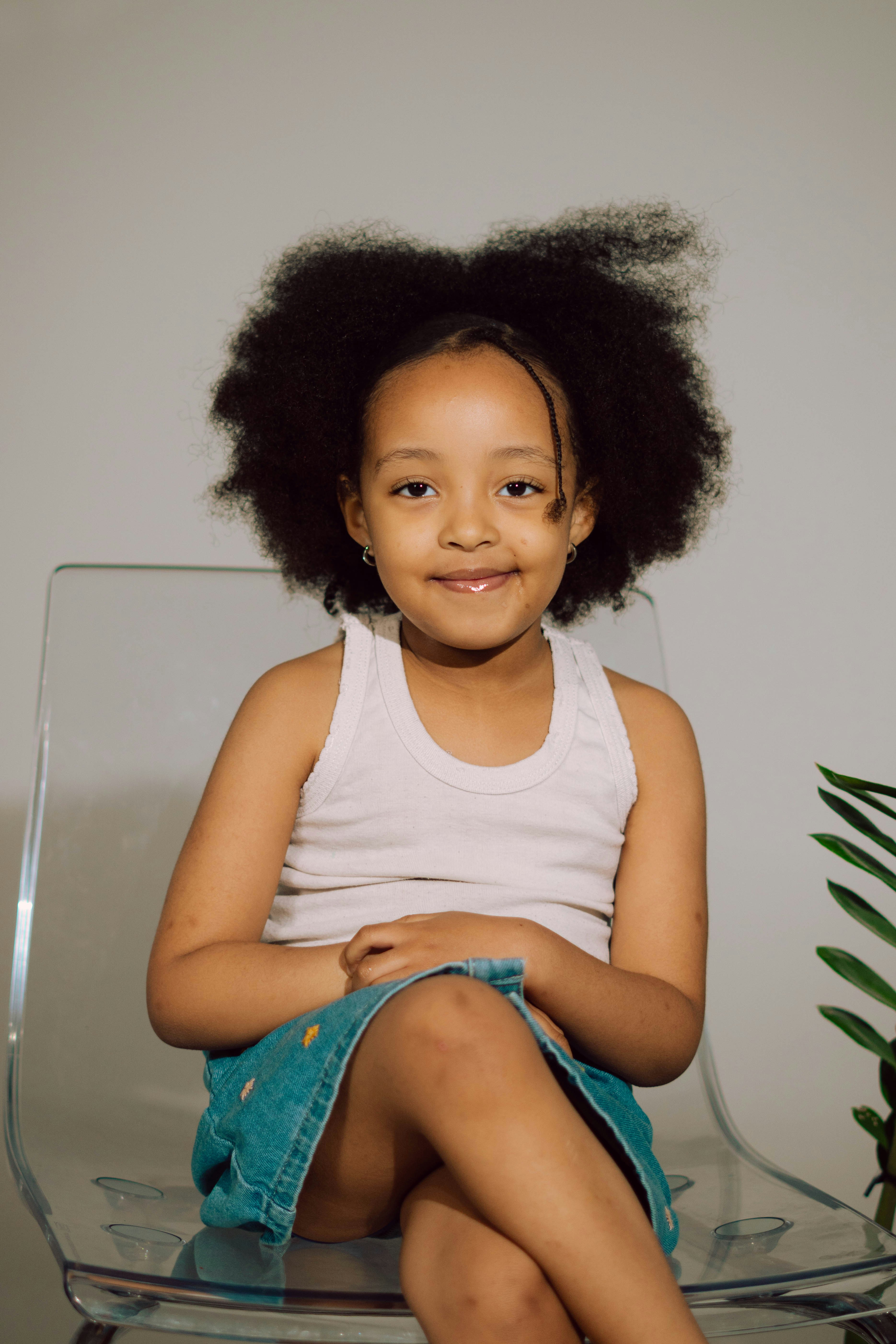 Smiling Confidence: A Quiet Portrait on a Clear Chair