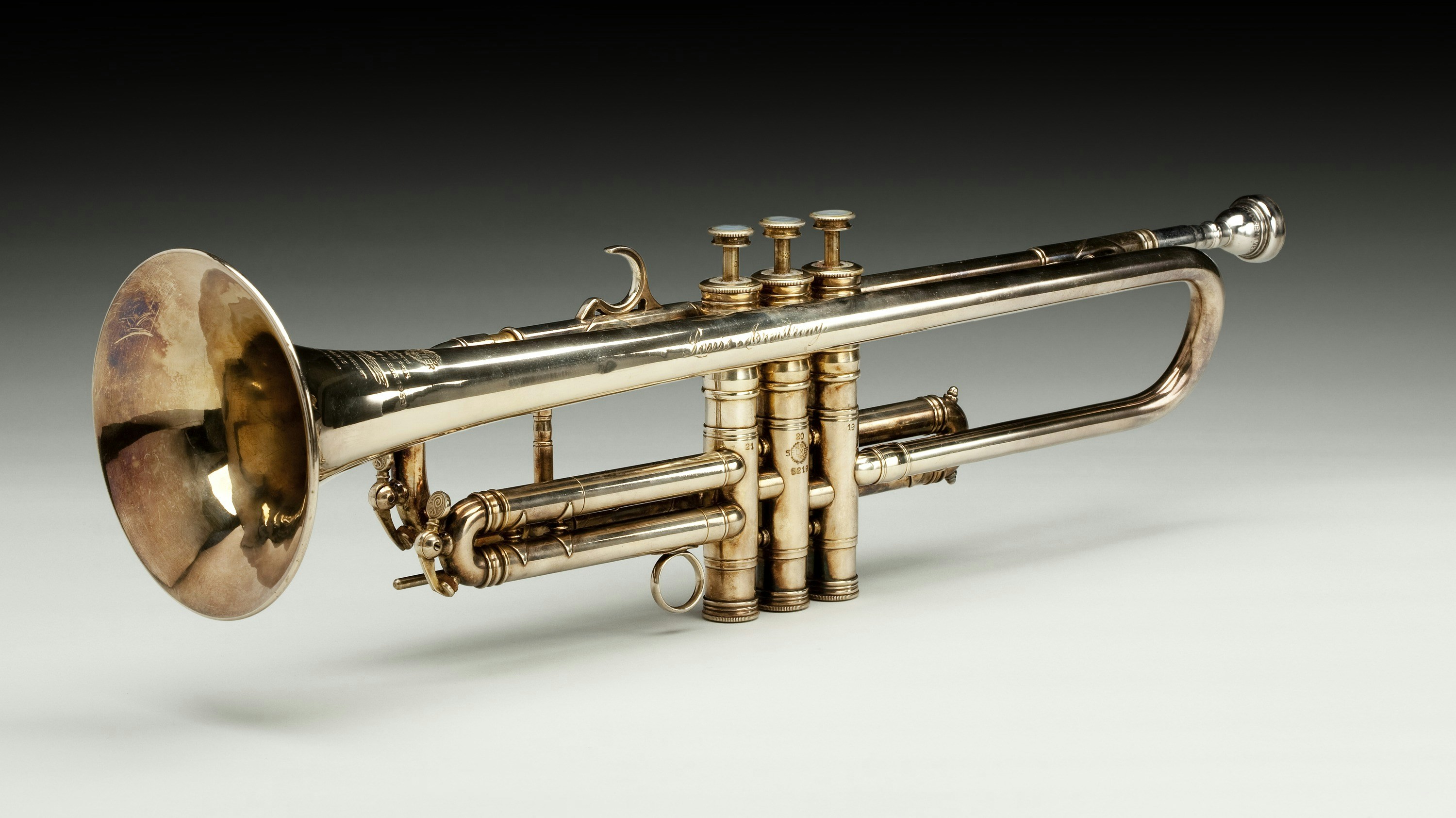 Bronze Resonance: A Vintage Trumpet Resting on a Studio Plain