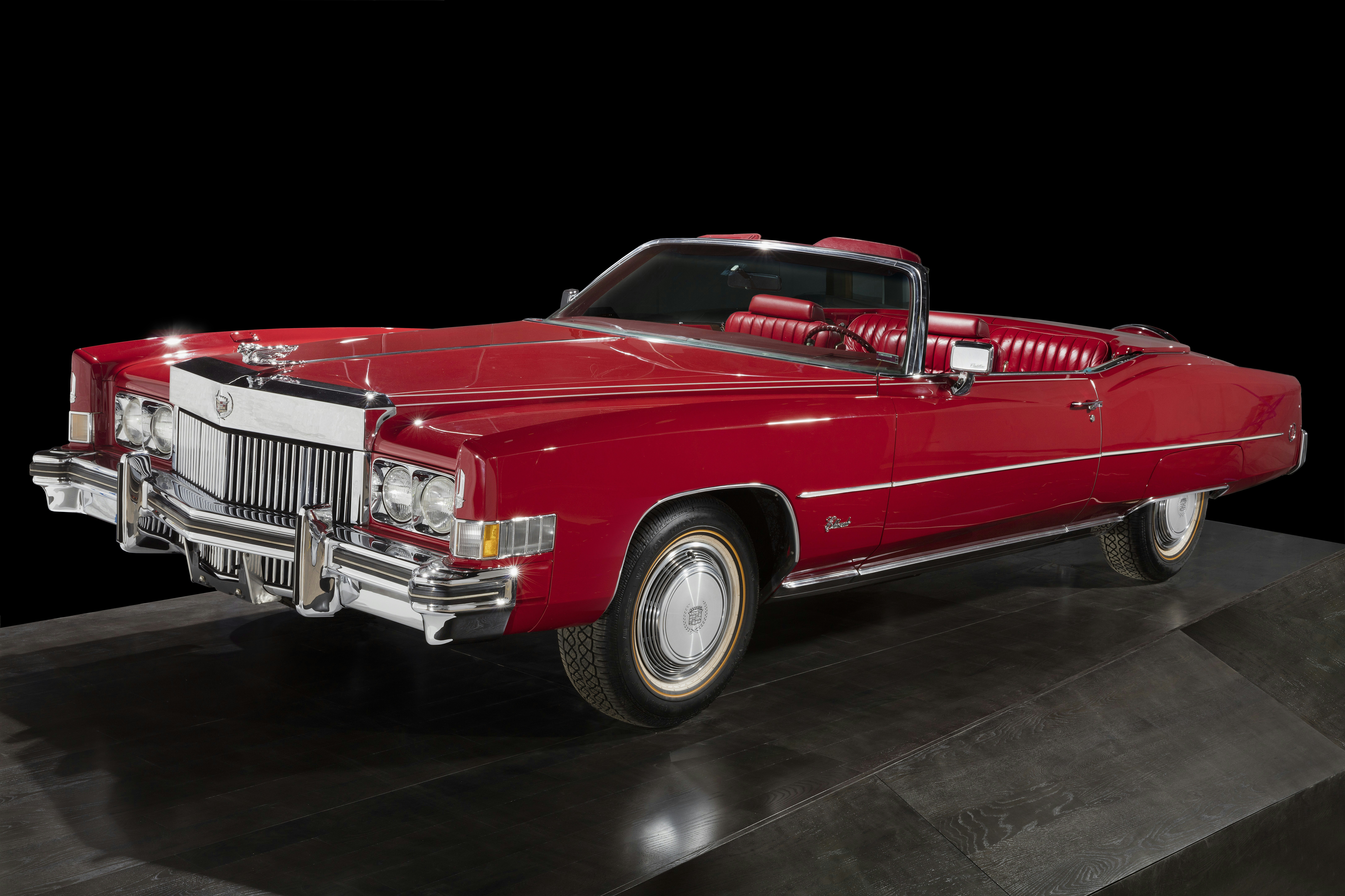 Glossy red classic: a landmark Convertible on a black stage