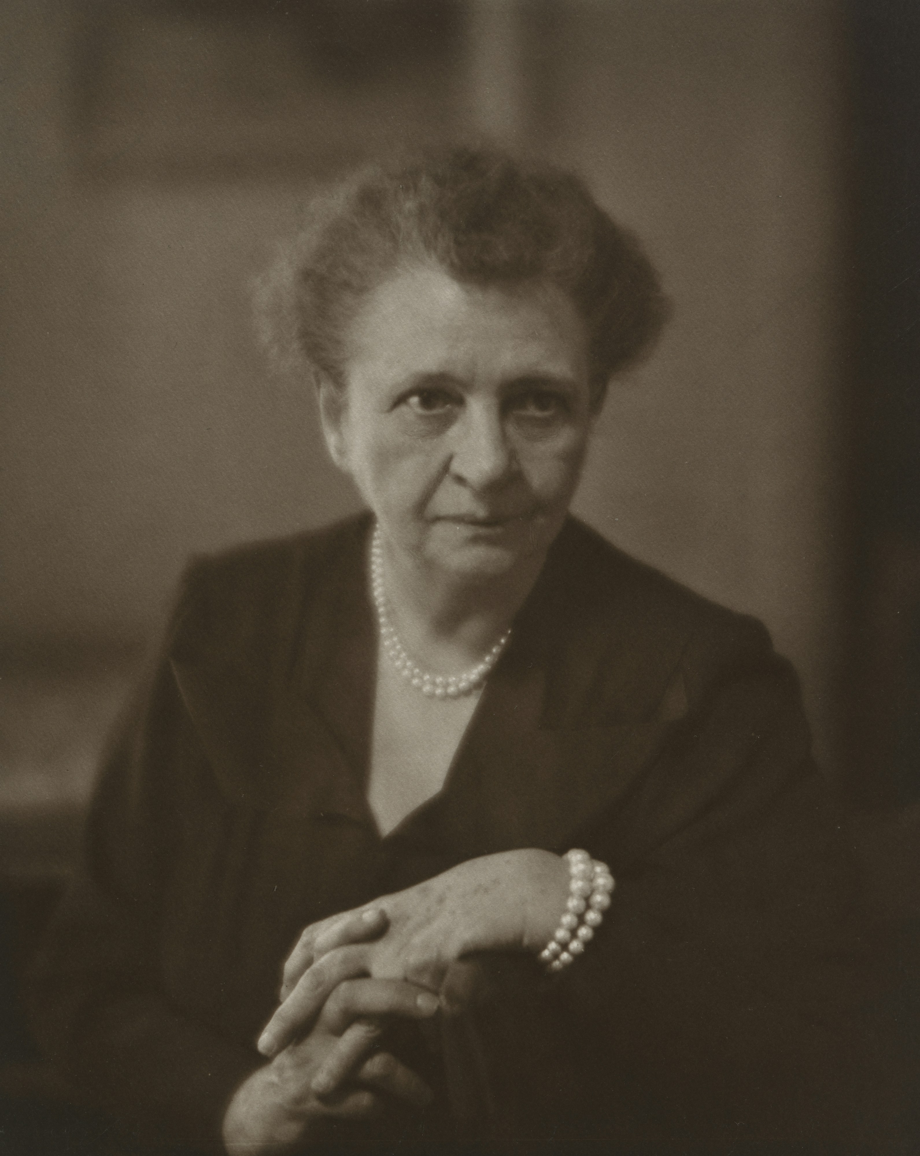 Portrait of Quiet Dignity: A Pearl-Necklaced Elder in Sepia