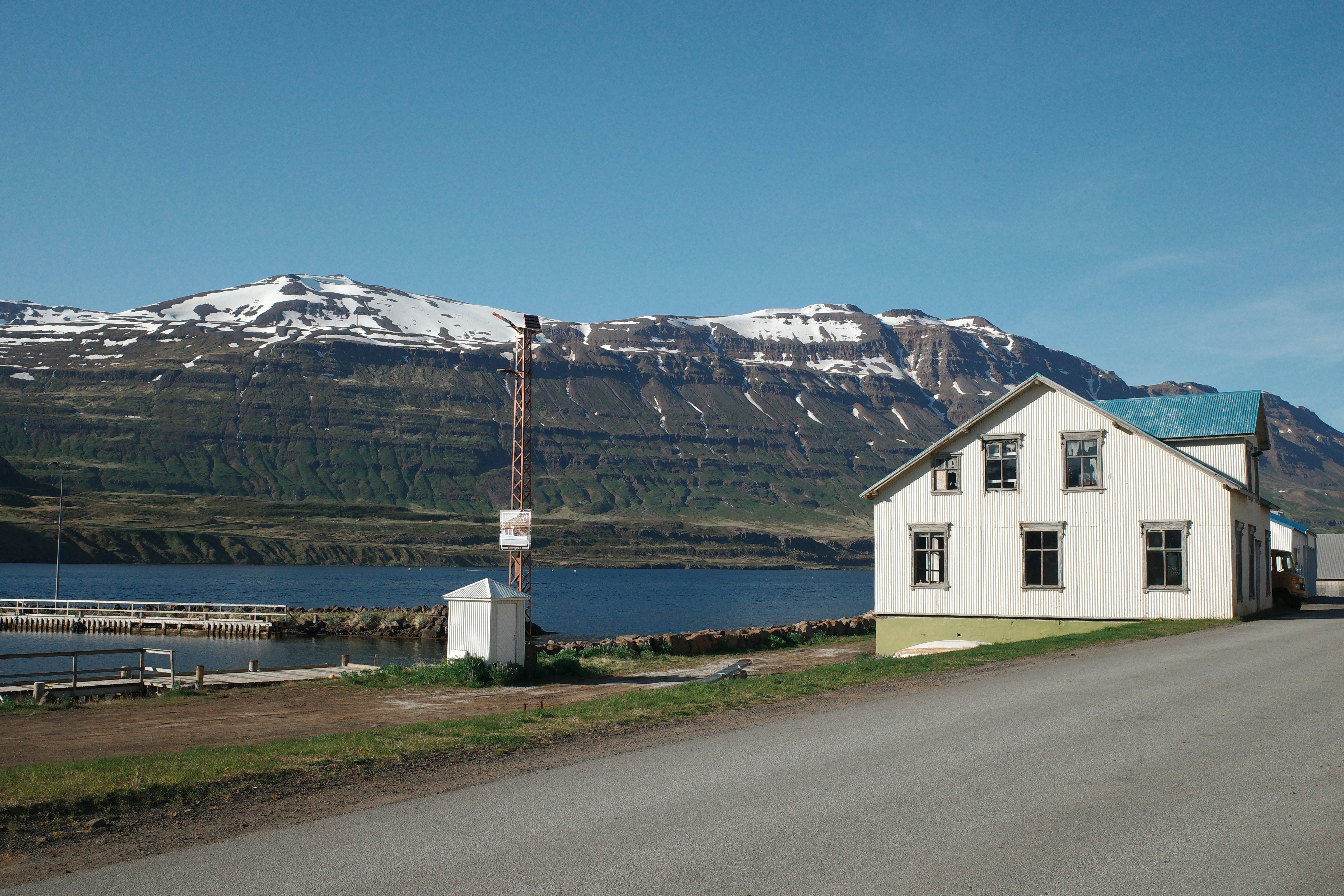 Harbor-side Cabin Beneath Snow-dusted Cliffs