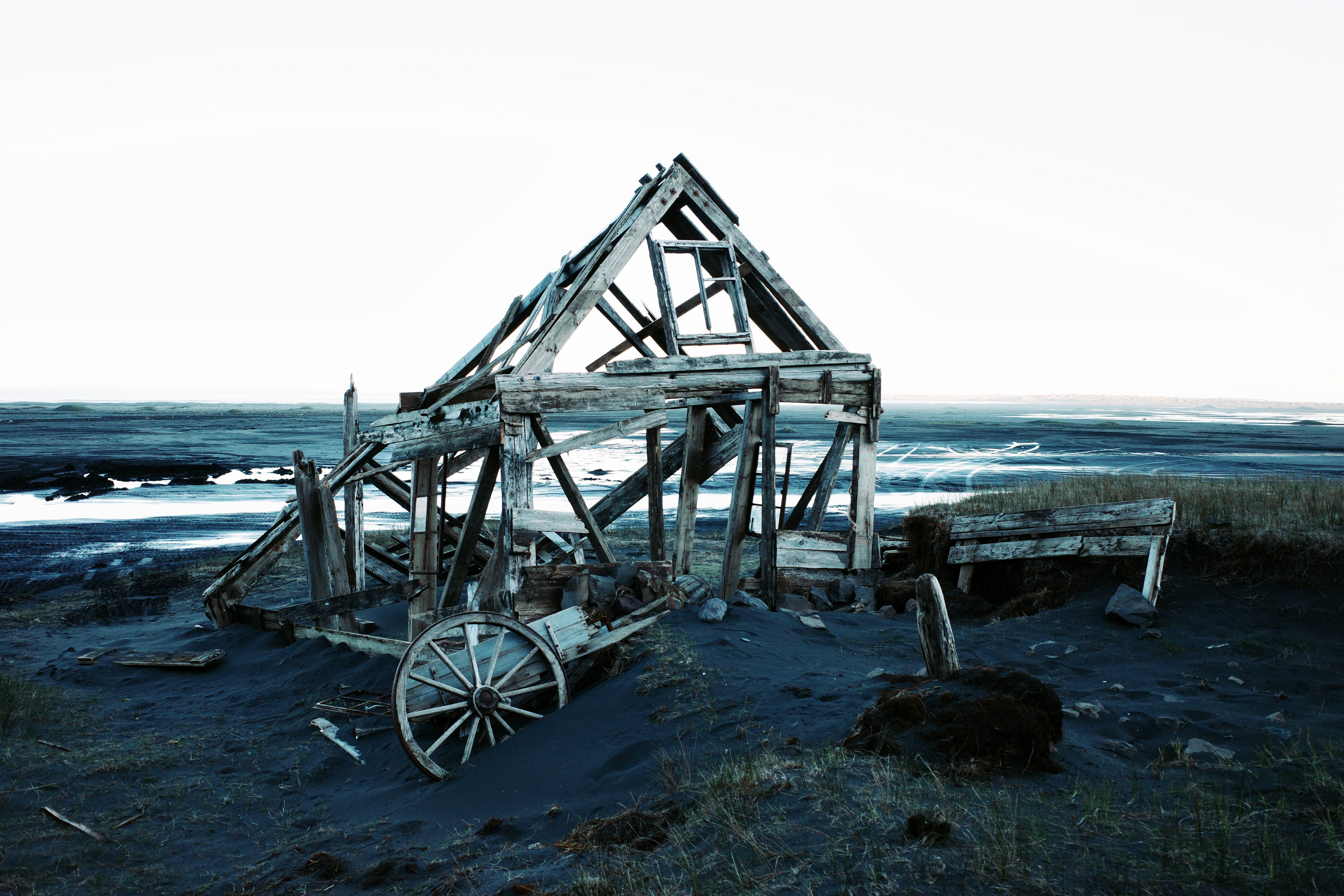 Weathered Shack on the Dunes: Crumbling Timber and a Detached Wheel