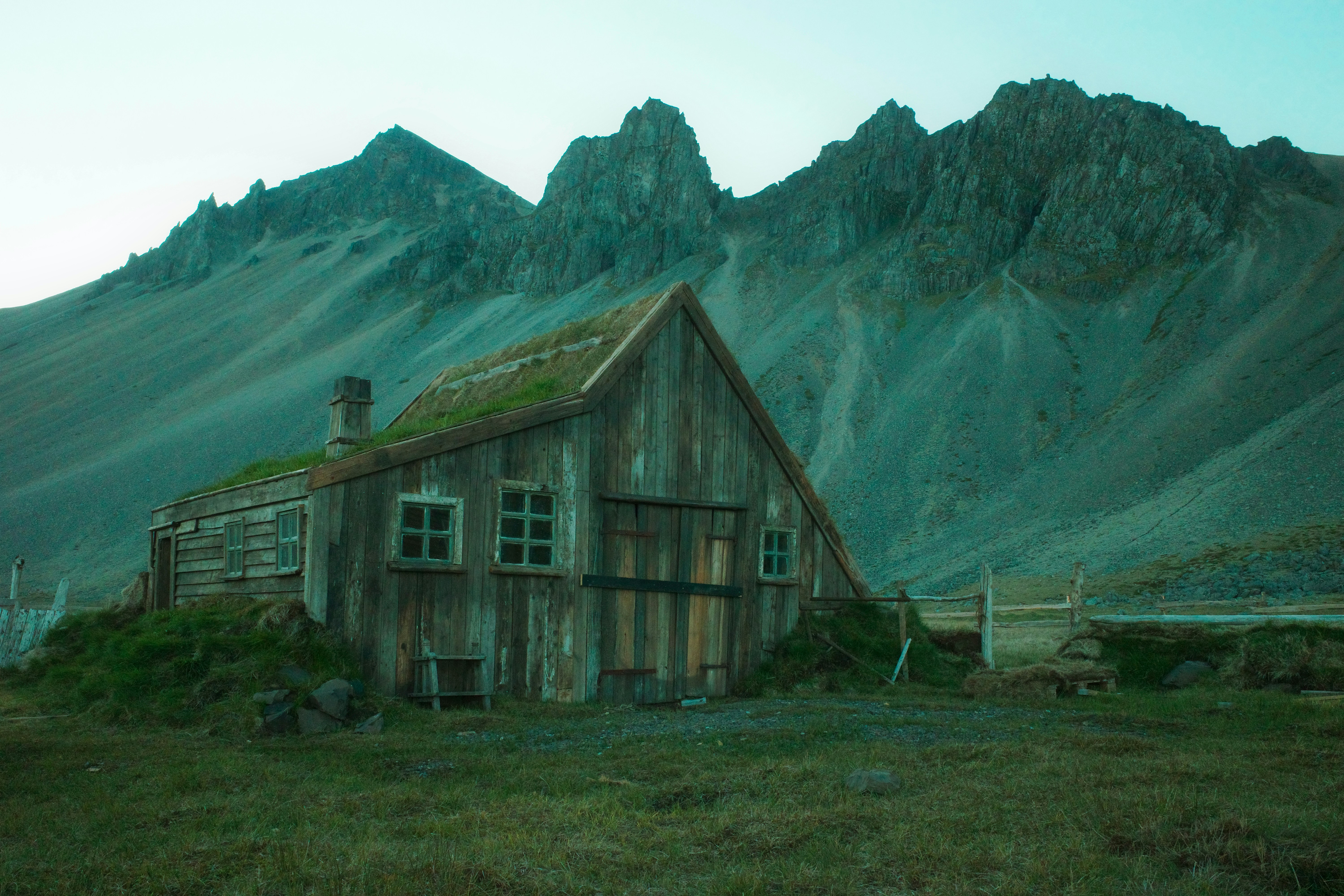 Weathered Cabin Nestled at the Foot of Jagged Peaks
