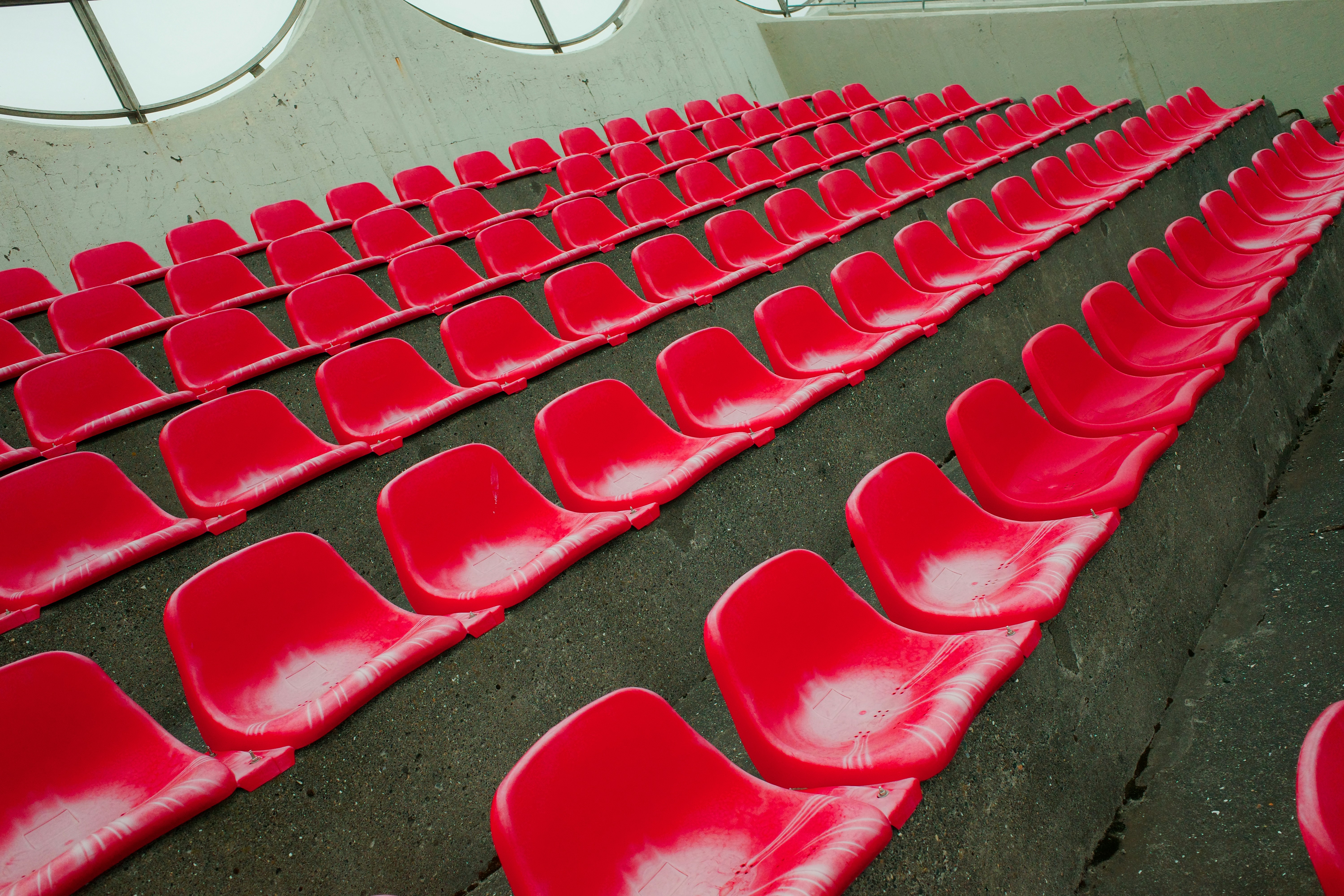 Red Rows in Quiet Stadium: A Sea of Empty Seats