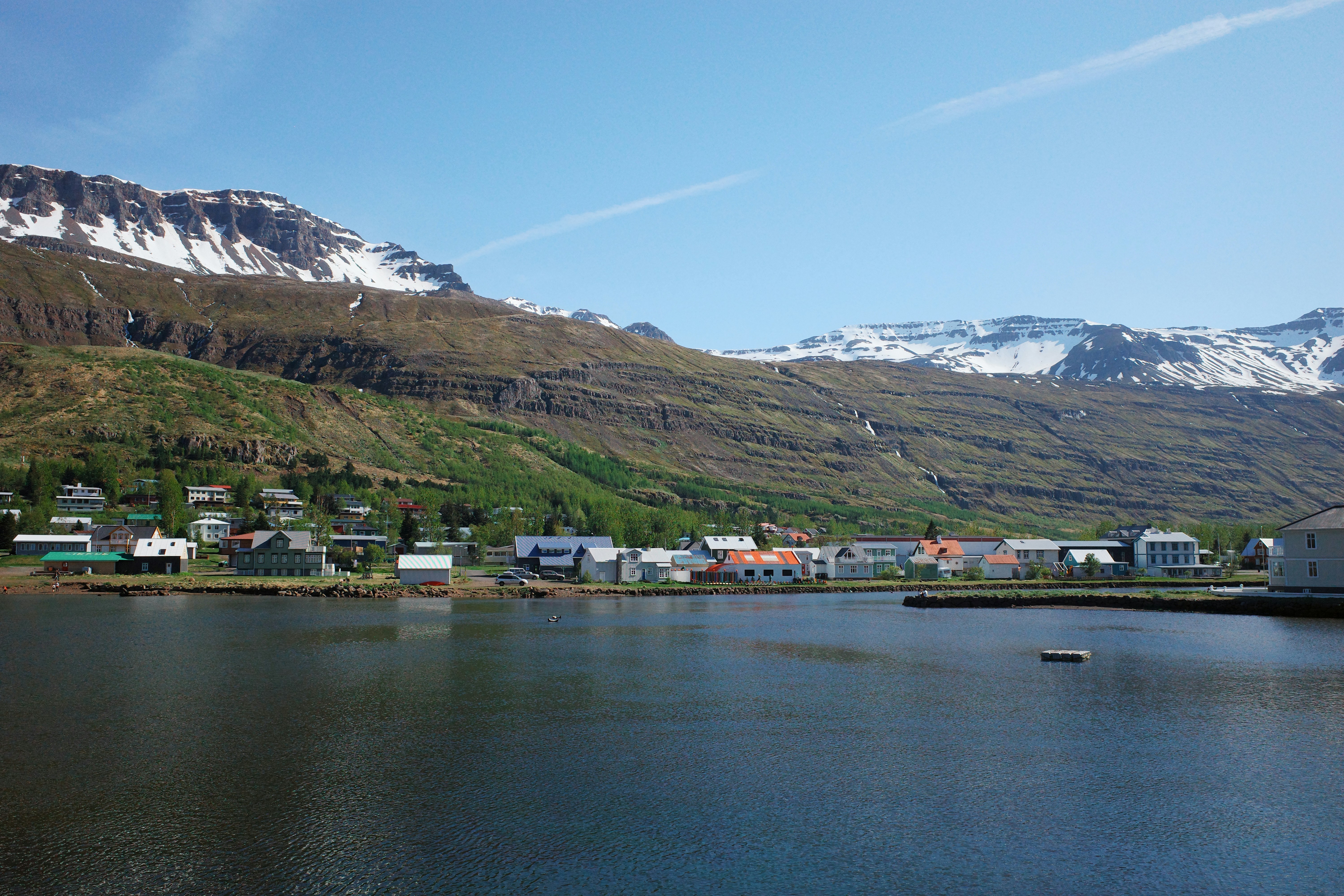Colorful riverside village at the foot of snow-dusted hills
