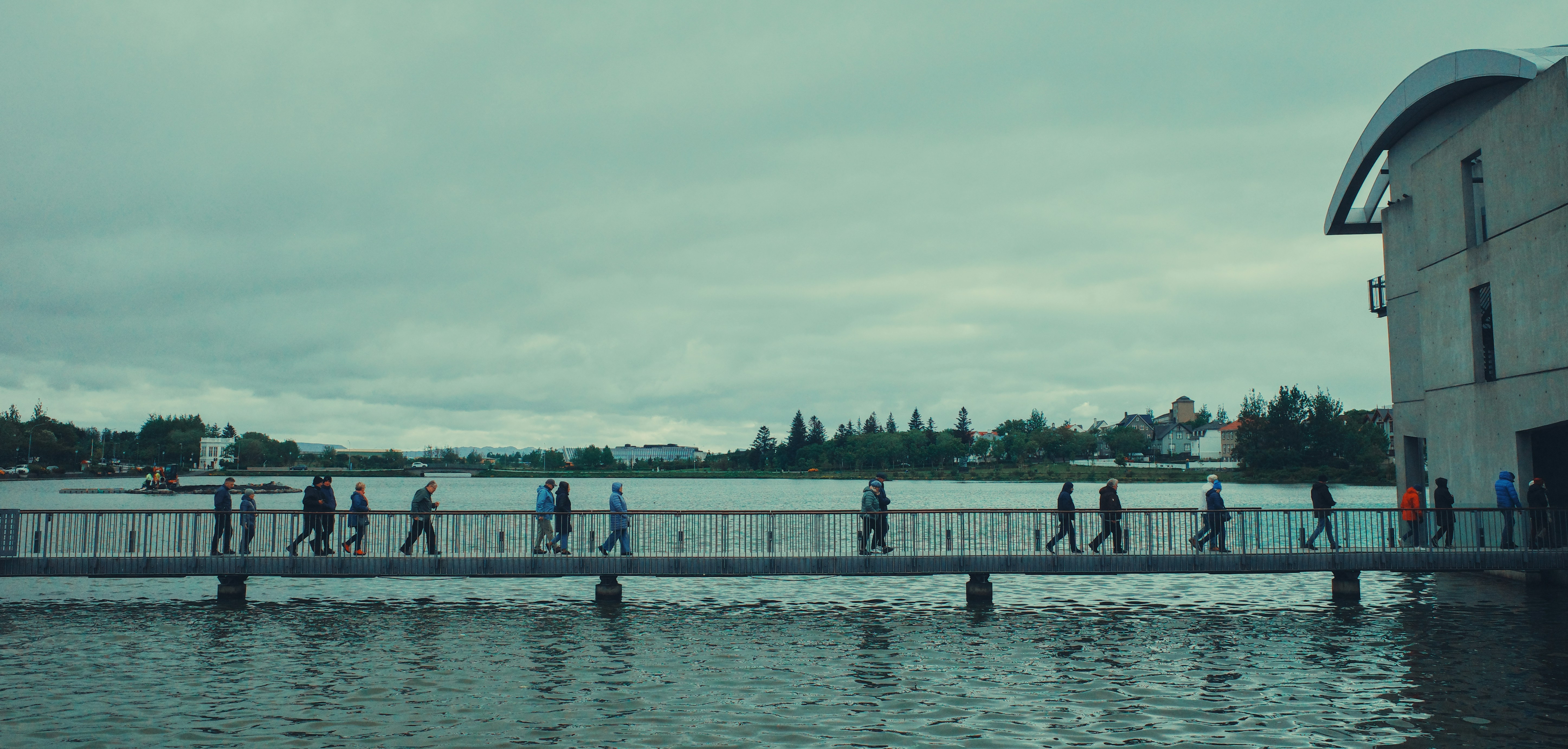Lone Line of Silhouettes Crossing a Distant Bridge