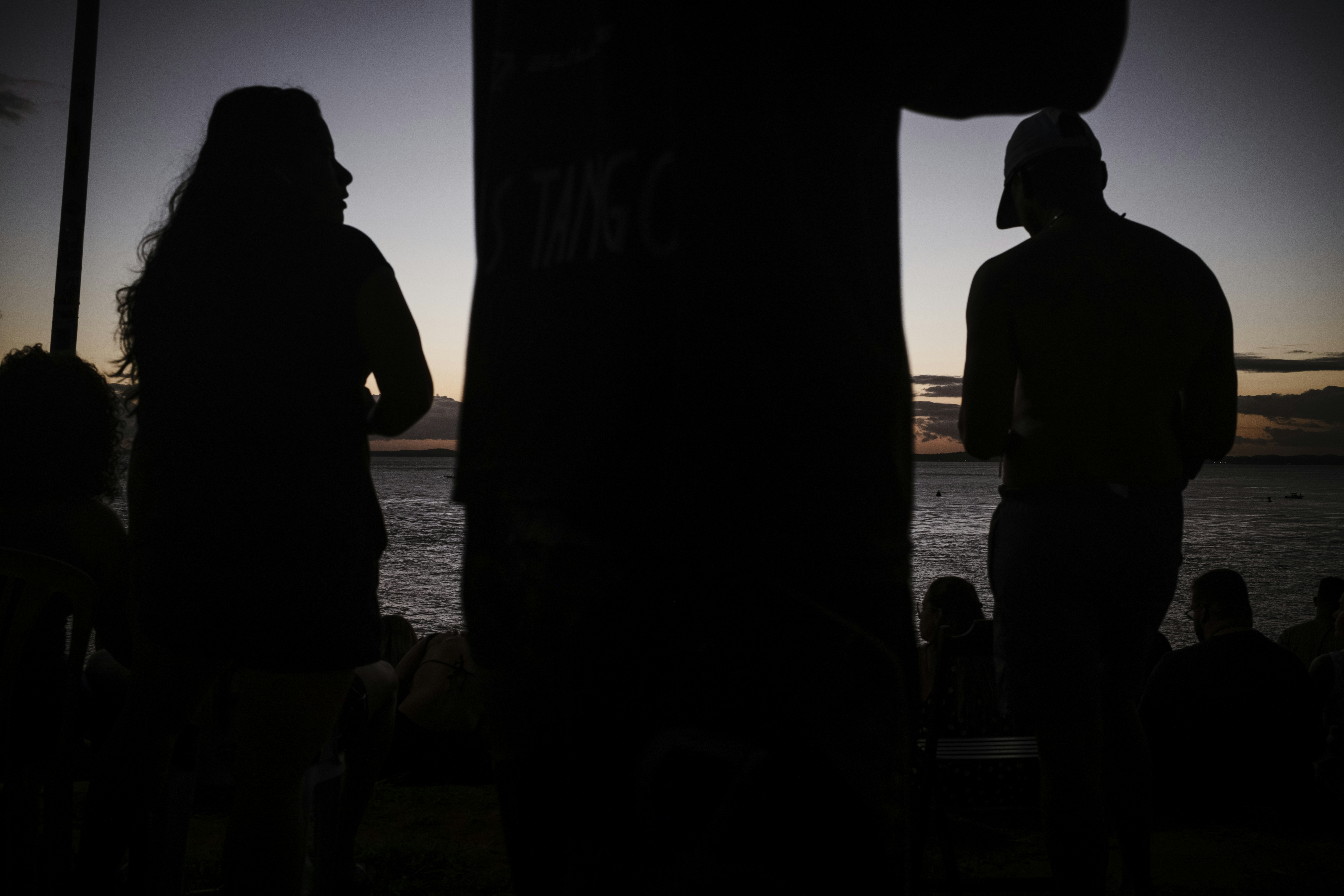 Silhouetted Figures at Dusk by the Water