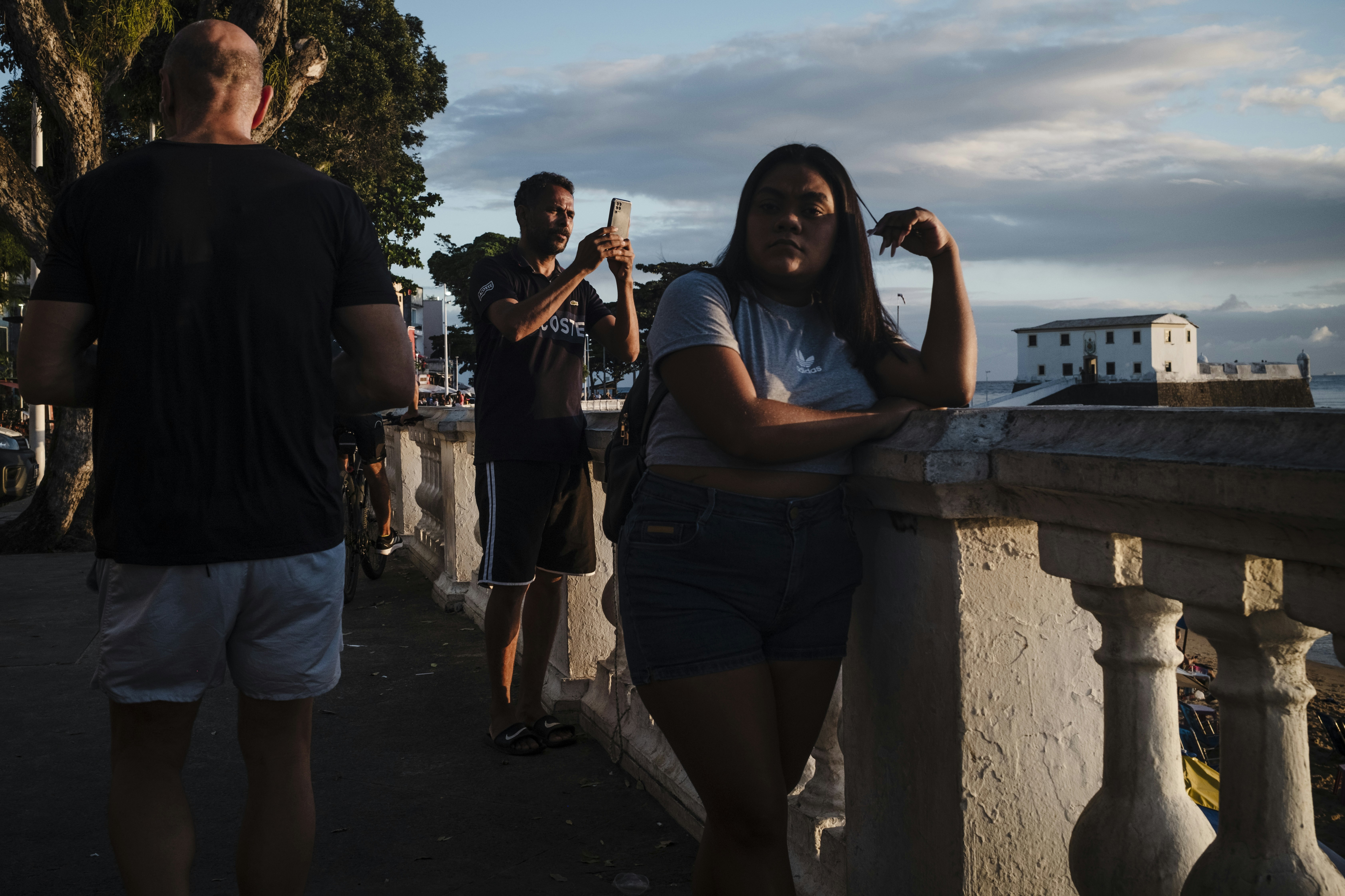 Rooftop Evening: Bystanders Pause by the Sea Wall
