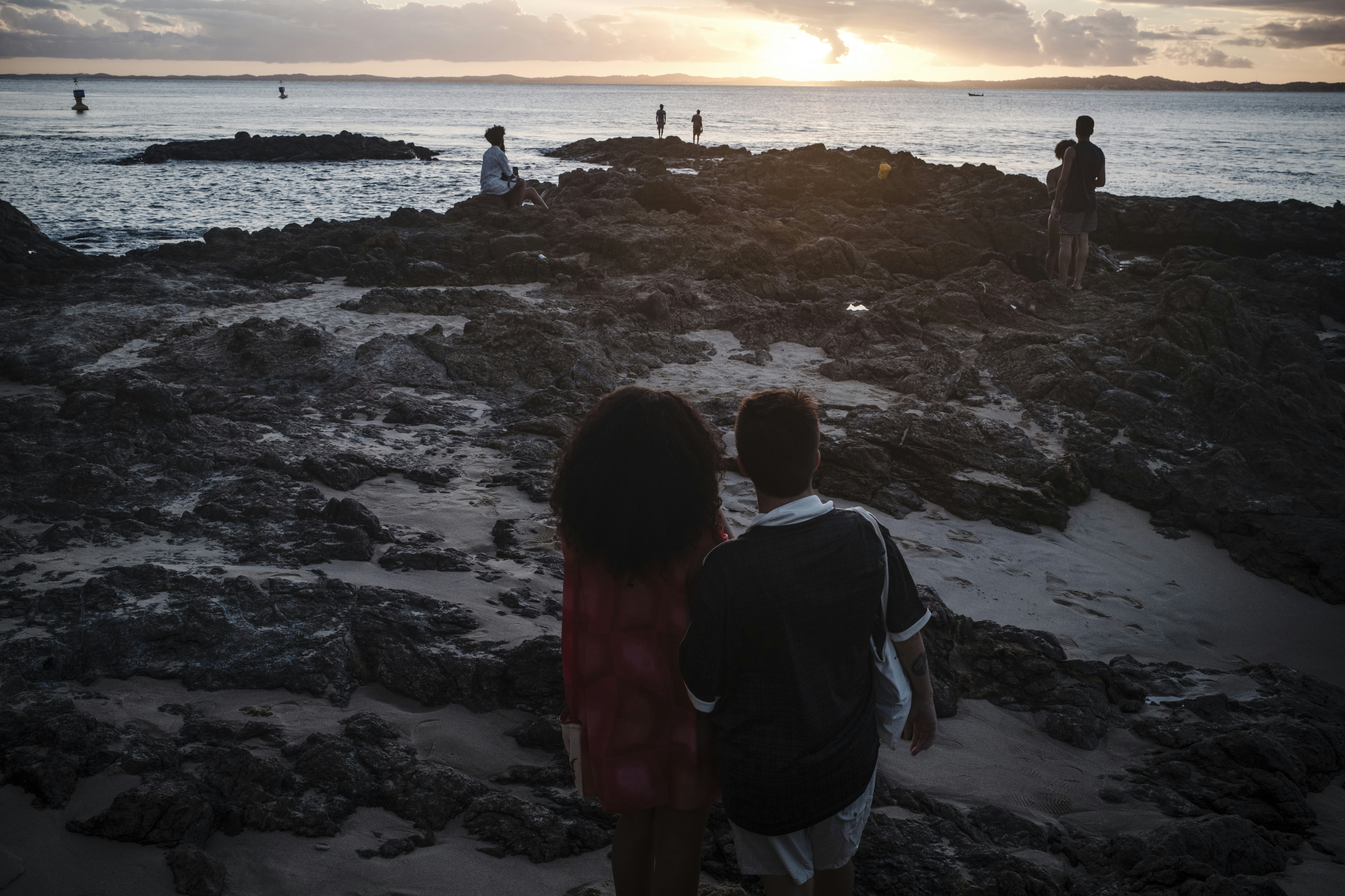 Two Figures at the Edge: Sunset Quiet on the Rocky Shore