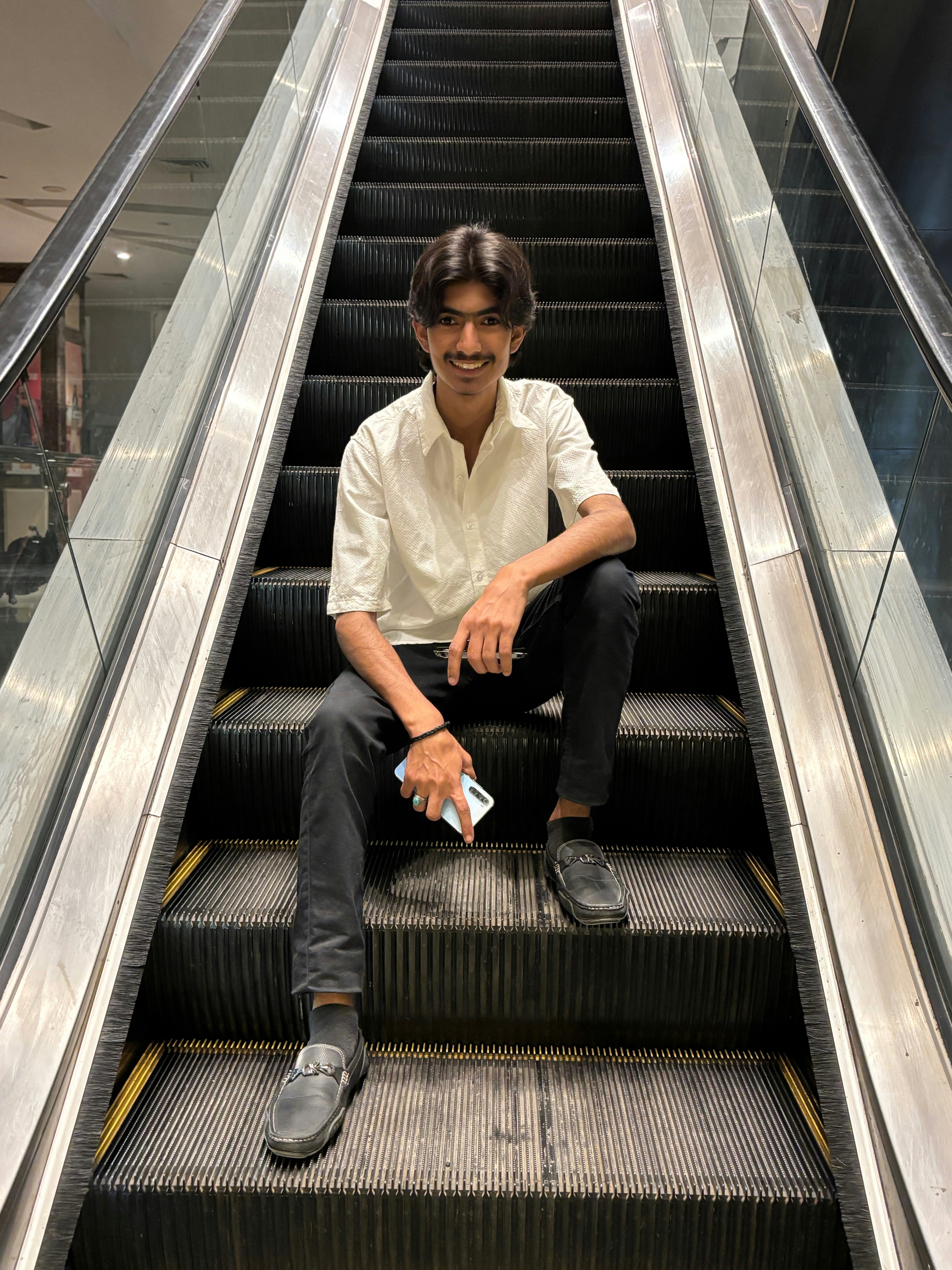 Casual portrait on an escalator: a relaxed smile in a sunlit shopping hall