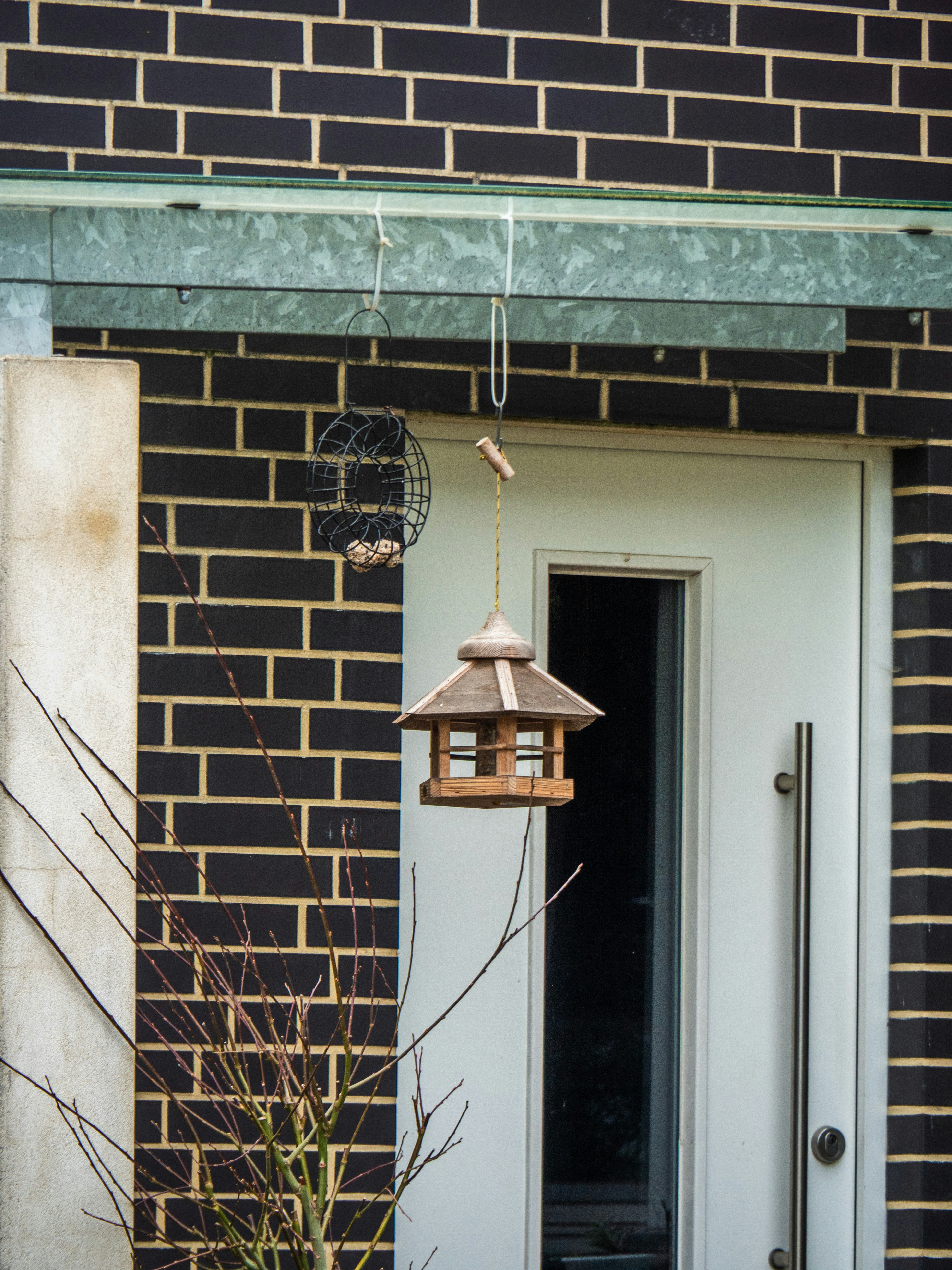 Wooden Birdhouse in Minimalist Brick Facade