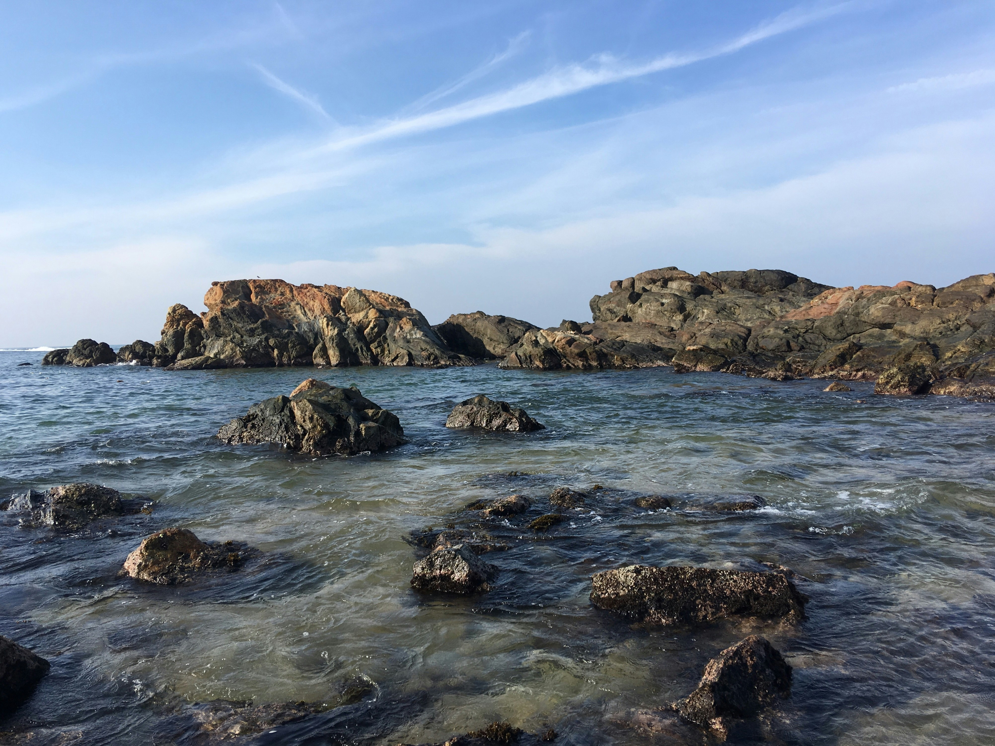 Coastal Outcrop at Dusk: Quiet Sea Among Weathered Rocks