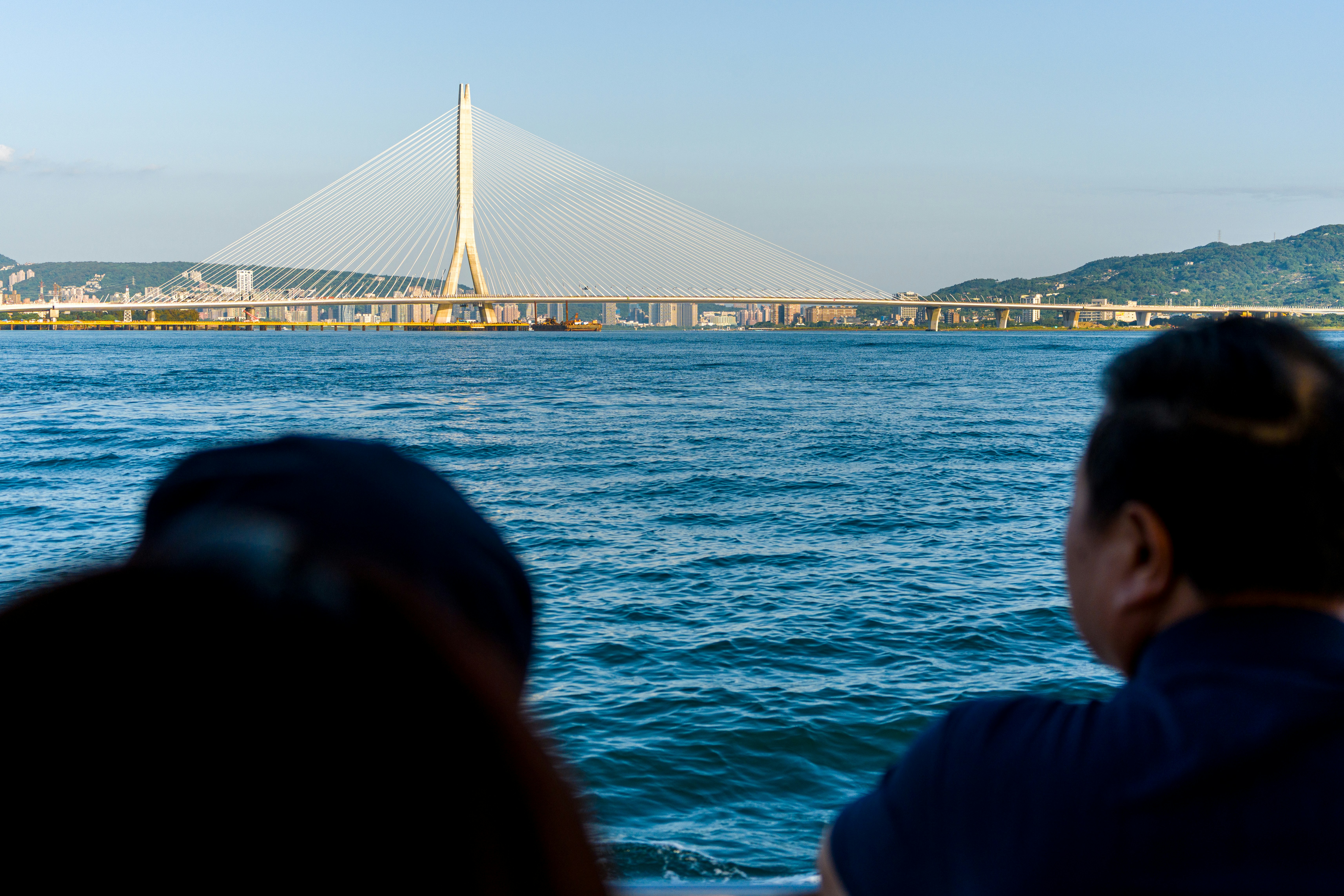 Bridge across the bay: silhouettes and cables against a calm sea