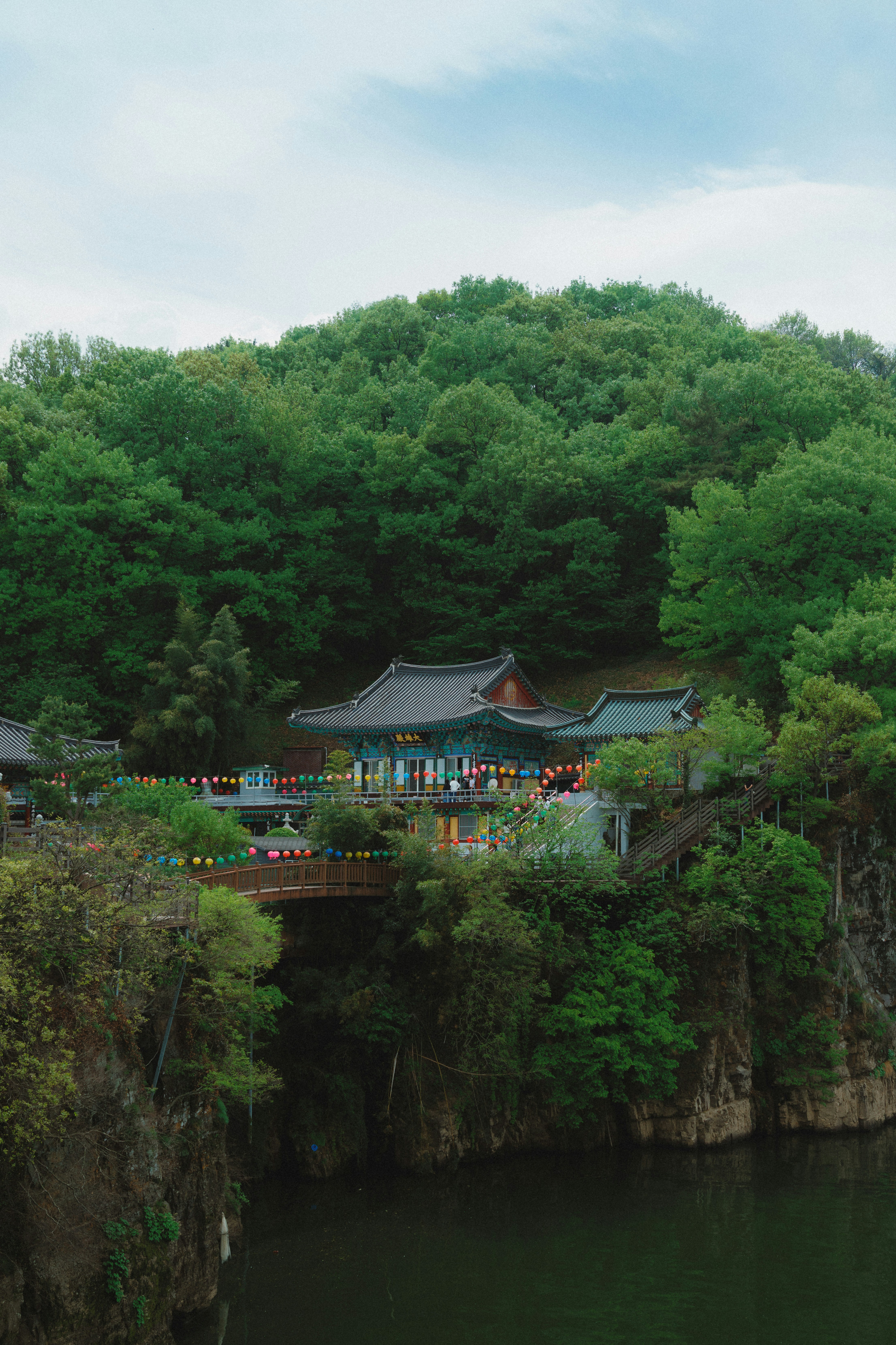 Temple on the Cliff: Colorful Lanterns Draped Across a Riverside Pavilion