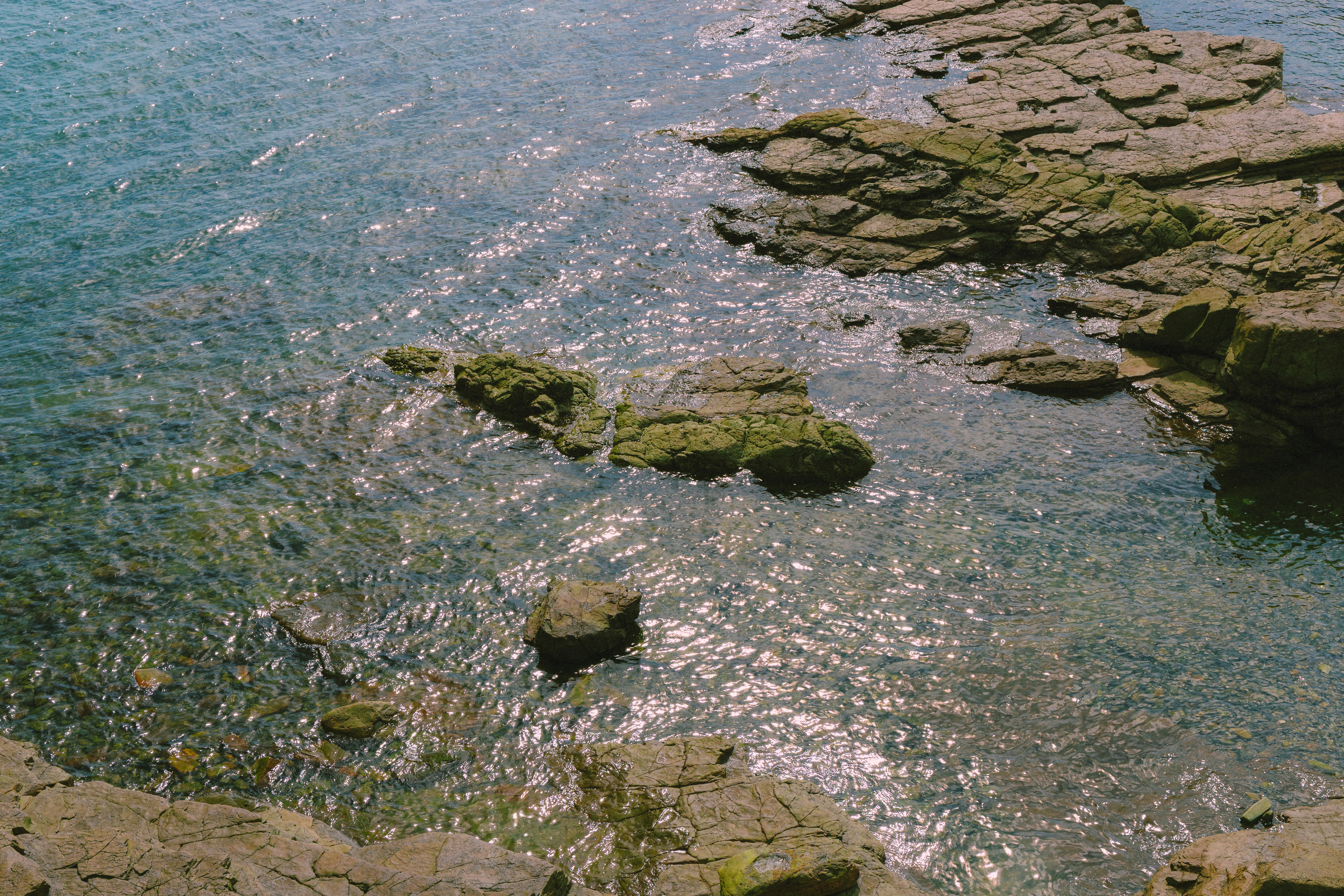 Sunlit Rocks and Rippling Tide