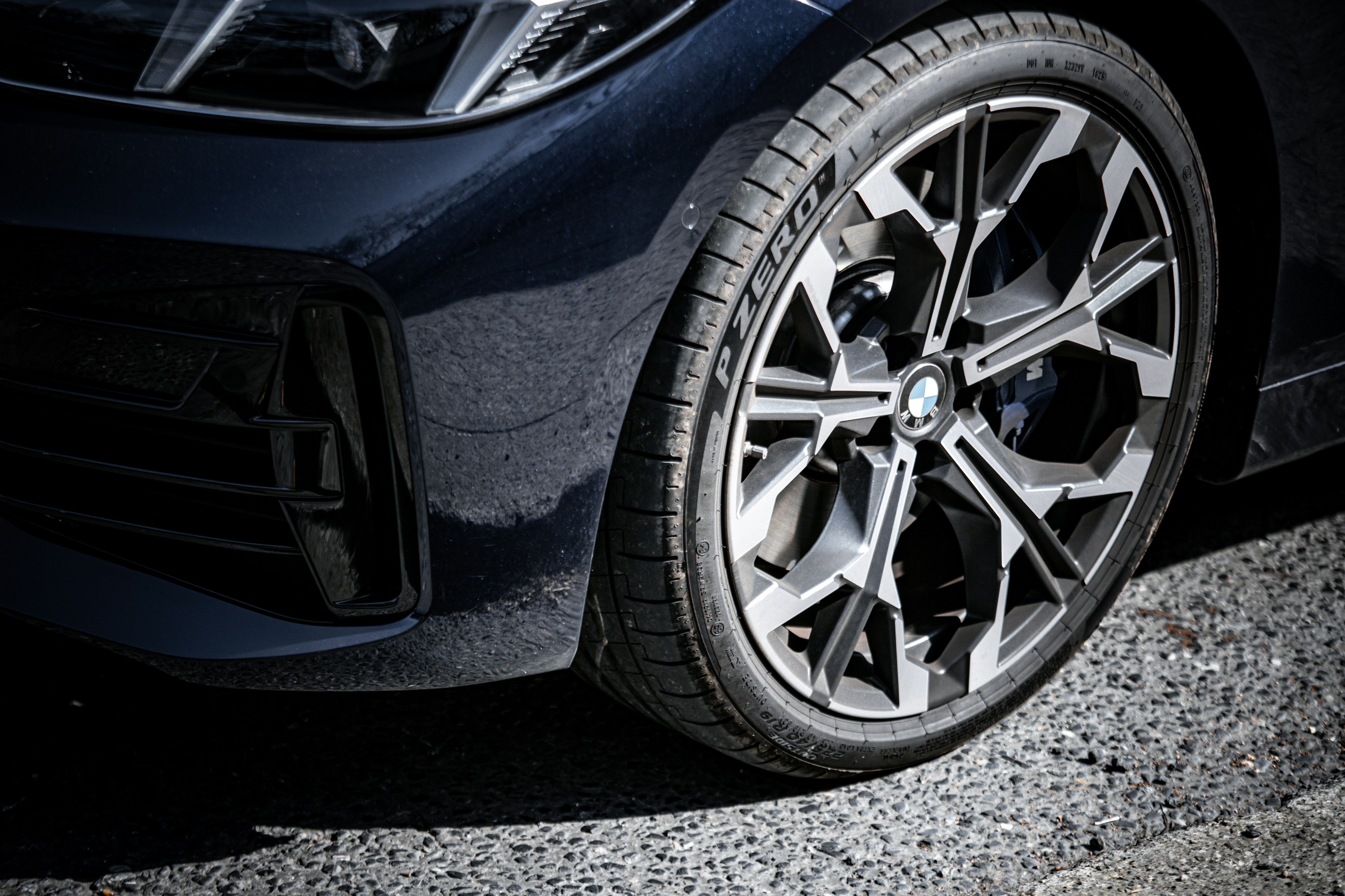 Low-Angle Glint: A Car’s Alloyed Focus on the Front Wheel