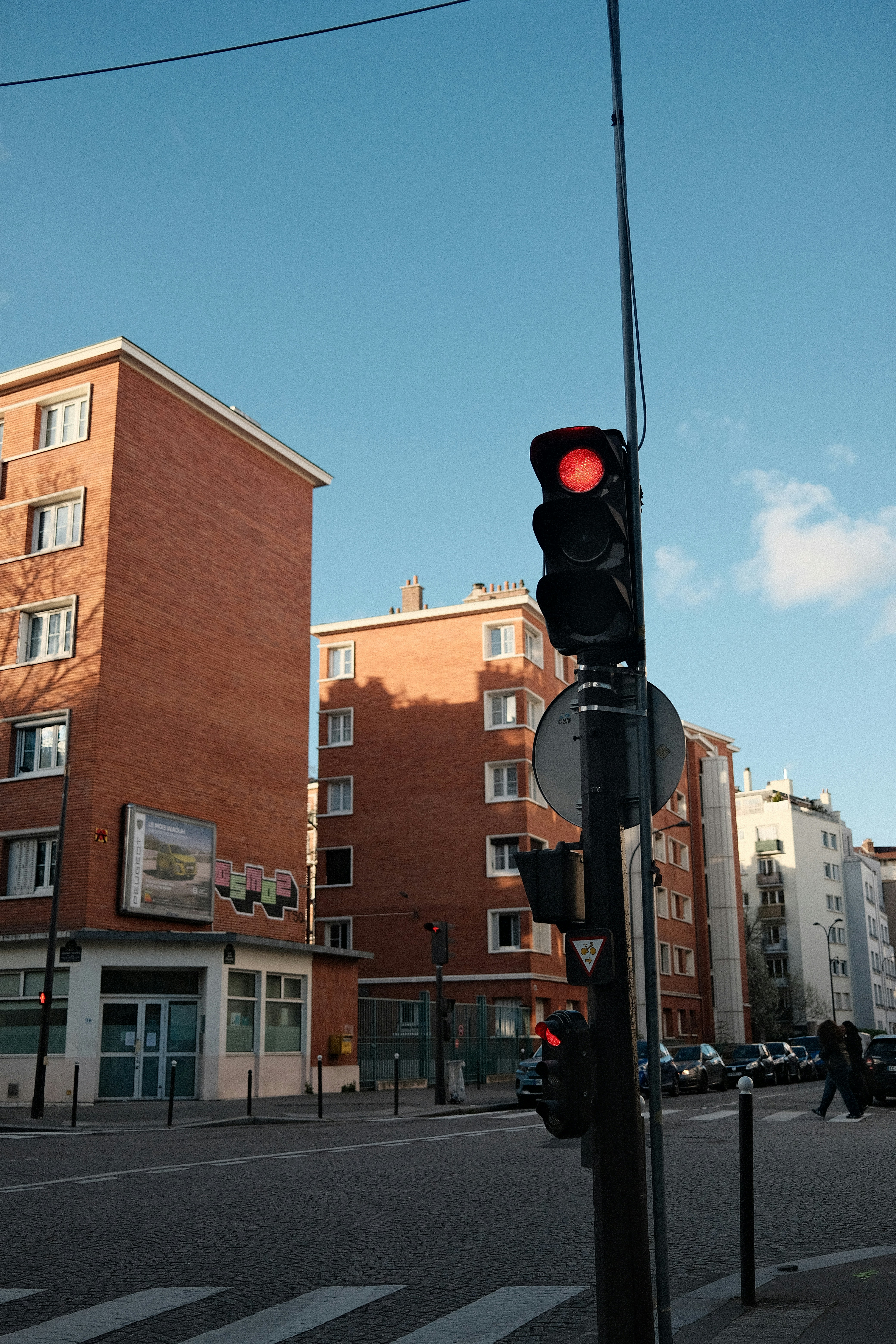 Street Pulse: Red Signal Under a Bright Apartment Sky