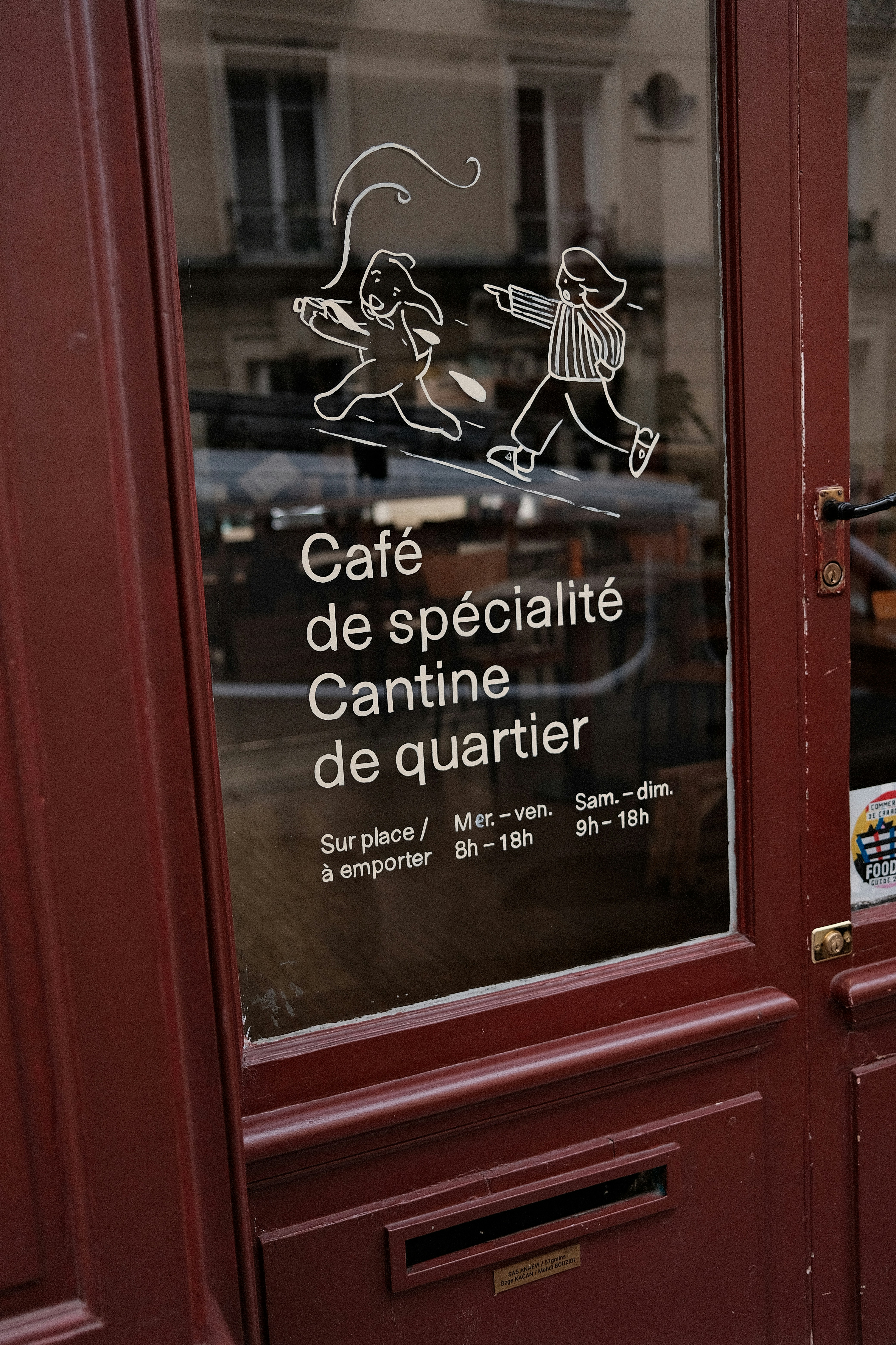 French Café Window: Hand-drawn Signage and Quiet Street Reflections