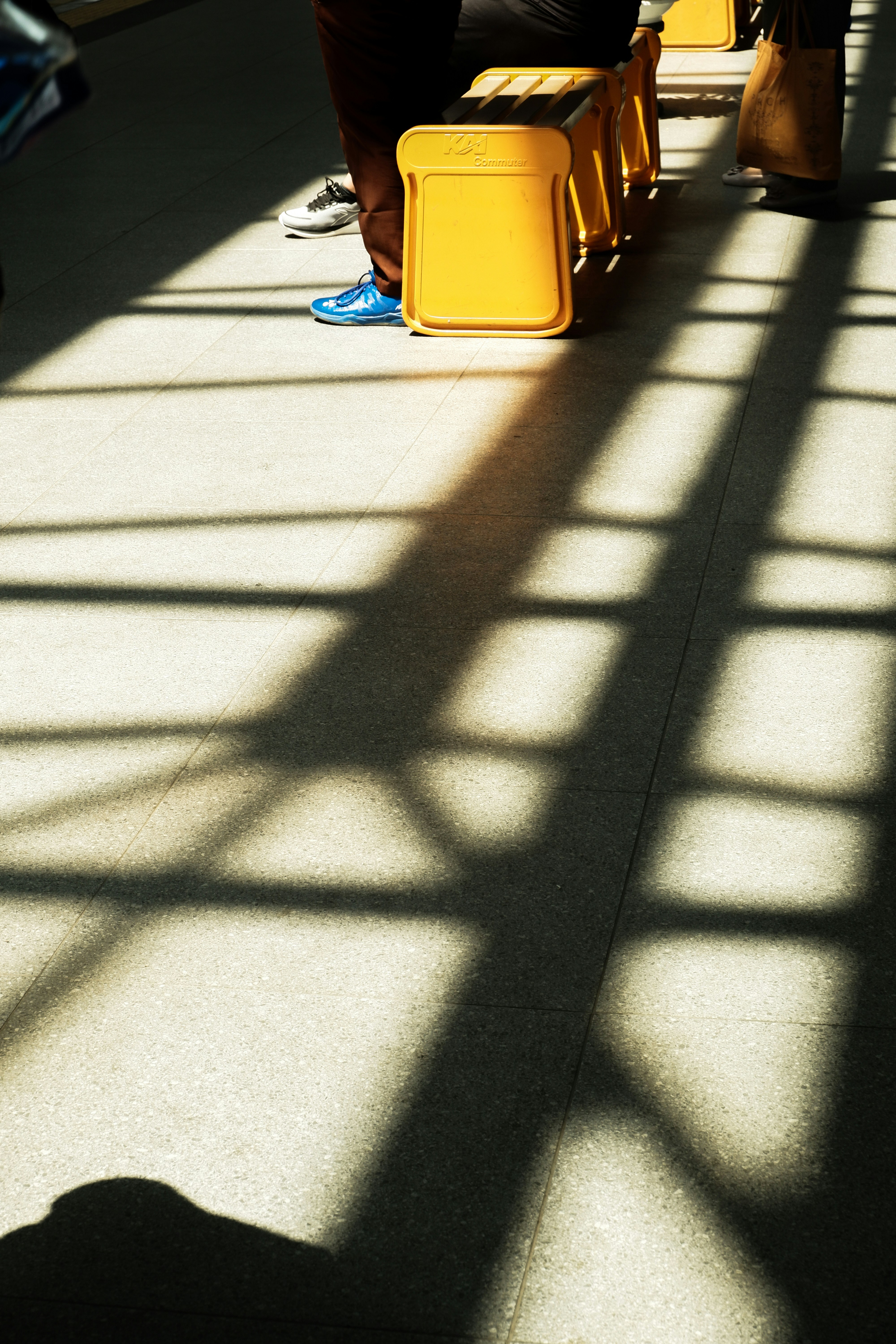 Sunlit Aisle: Orange Stools and Shadowed Grid