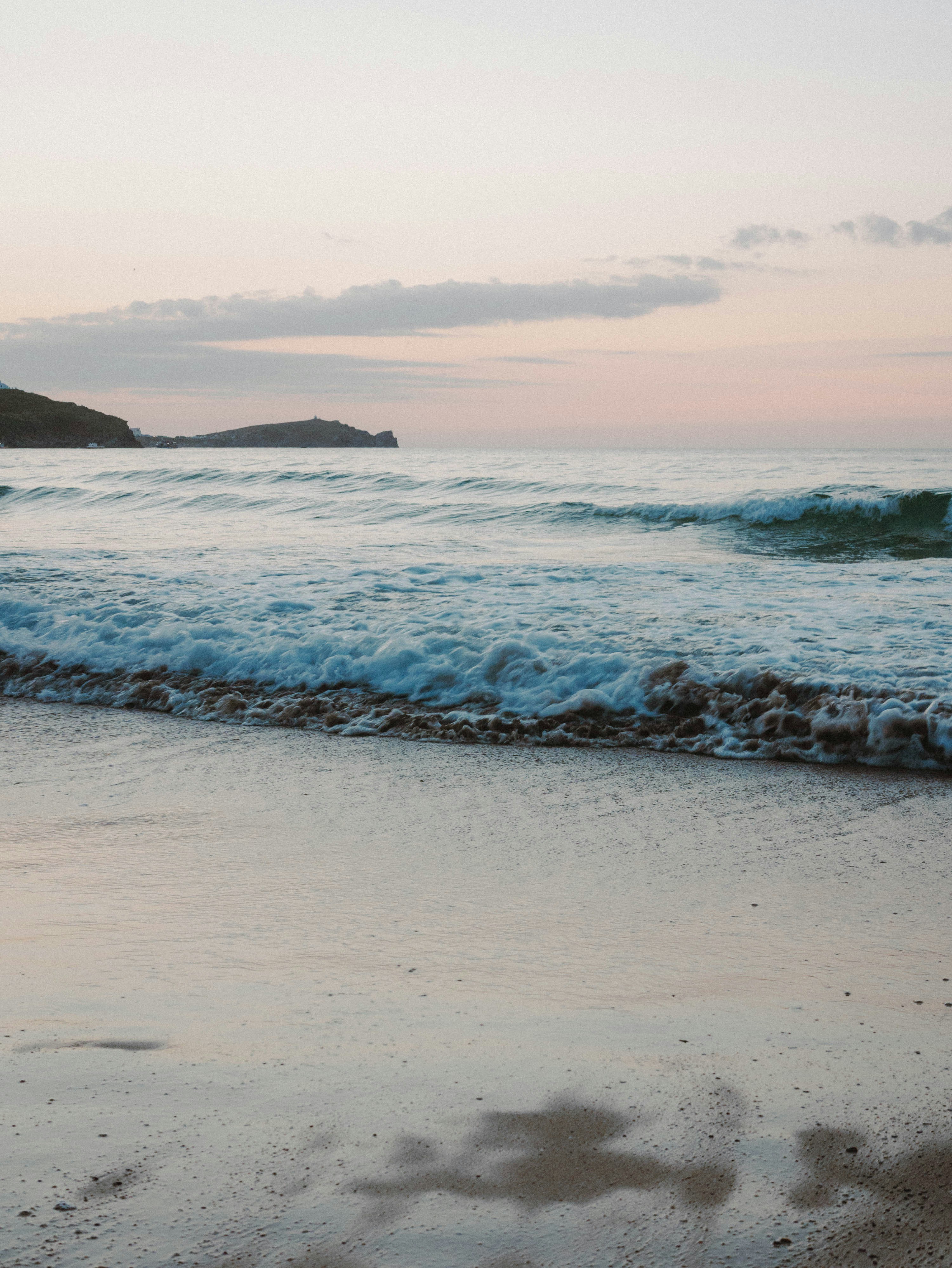 Sunlit Shoreline at Dusk: Gentle Waves and Soft Horizon