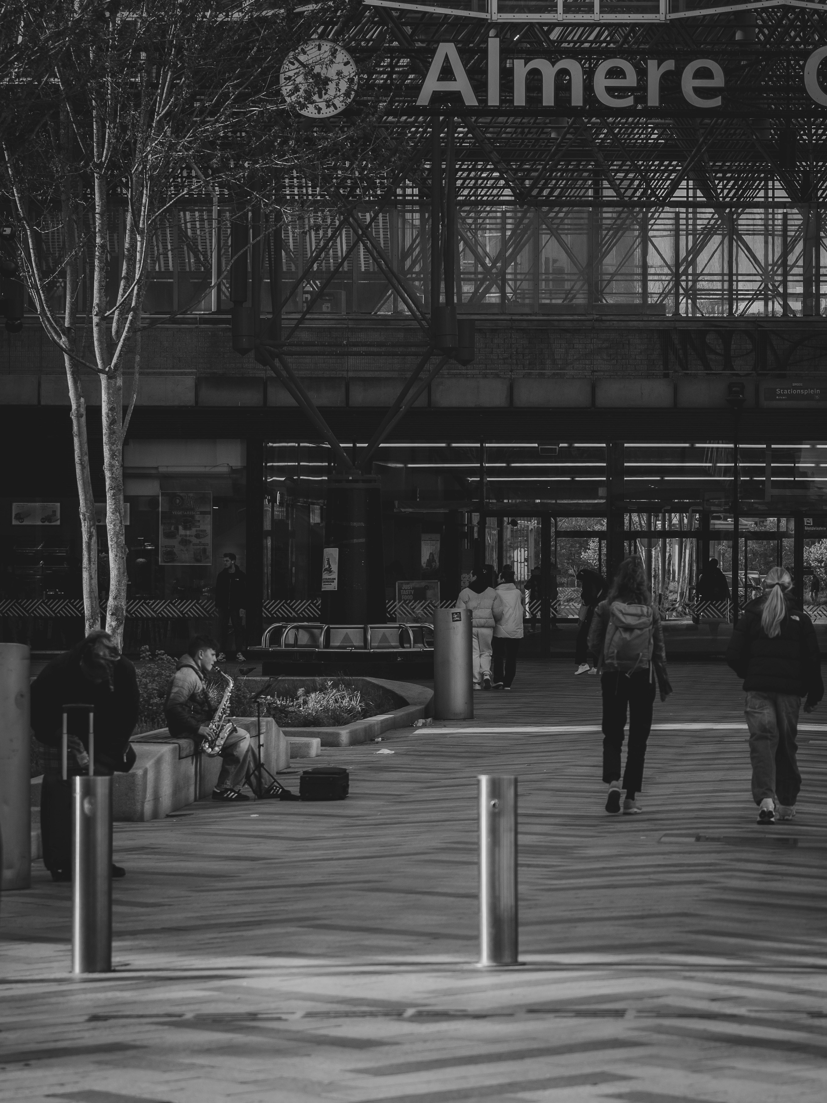Quiet Transit: People Walk Through a Monochrome City Entrance