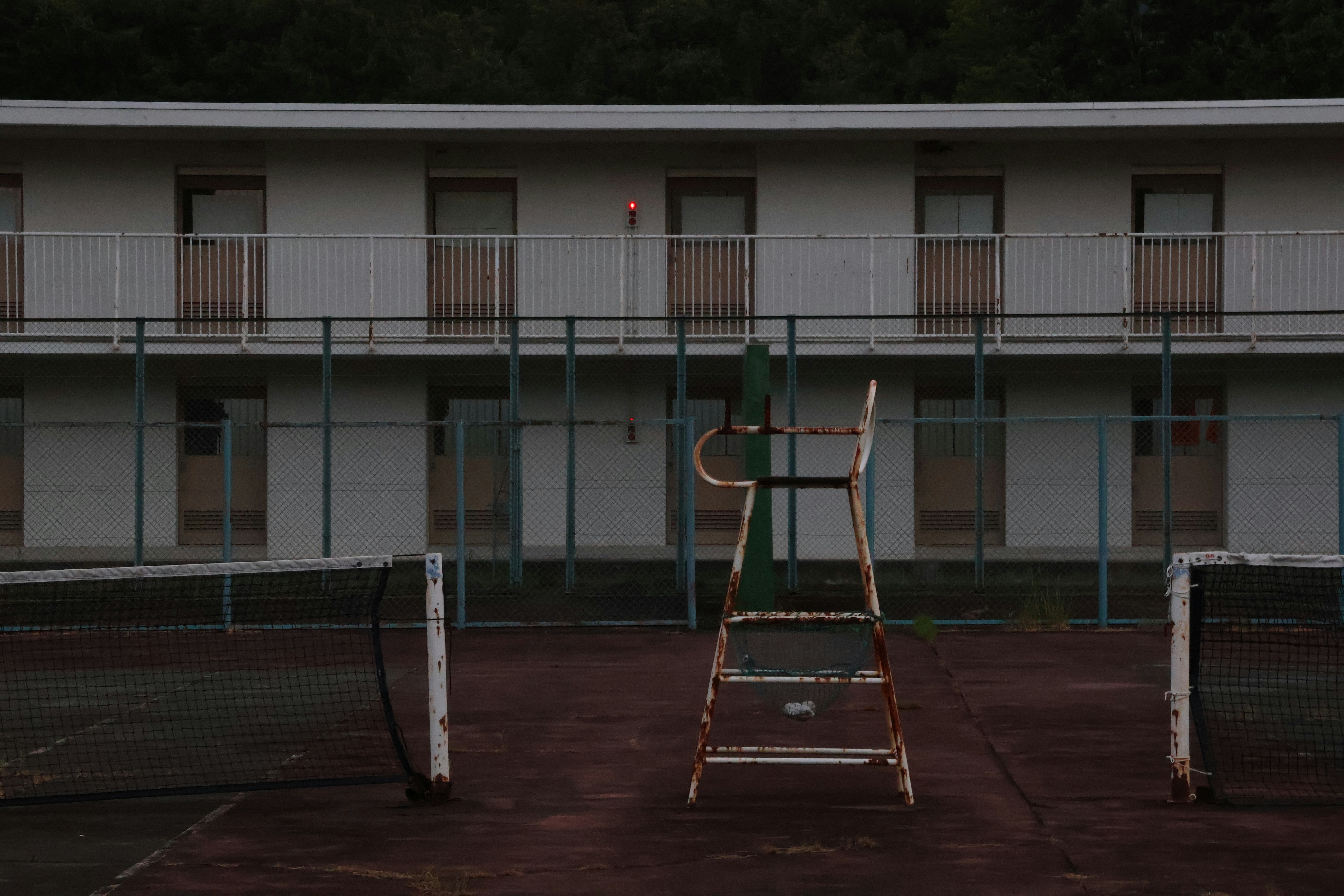 Abandoned Court at Dusk: The Rusted Lifeguard Stand Underlock