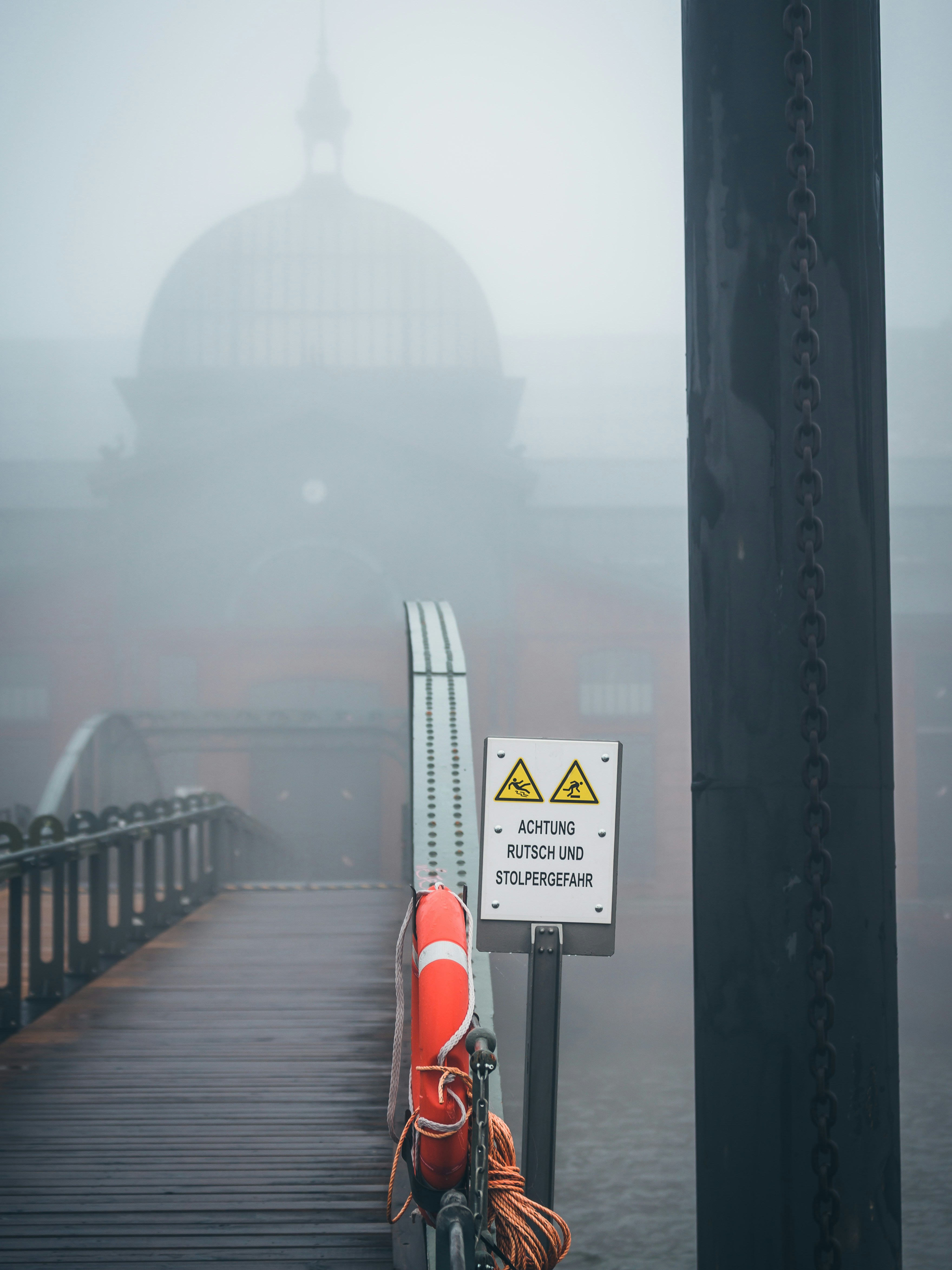 Misty Pier: Lifebuoy, Railing and Signguard in Quiet Fog