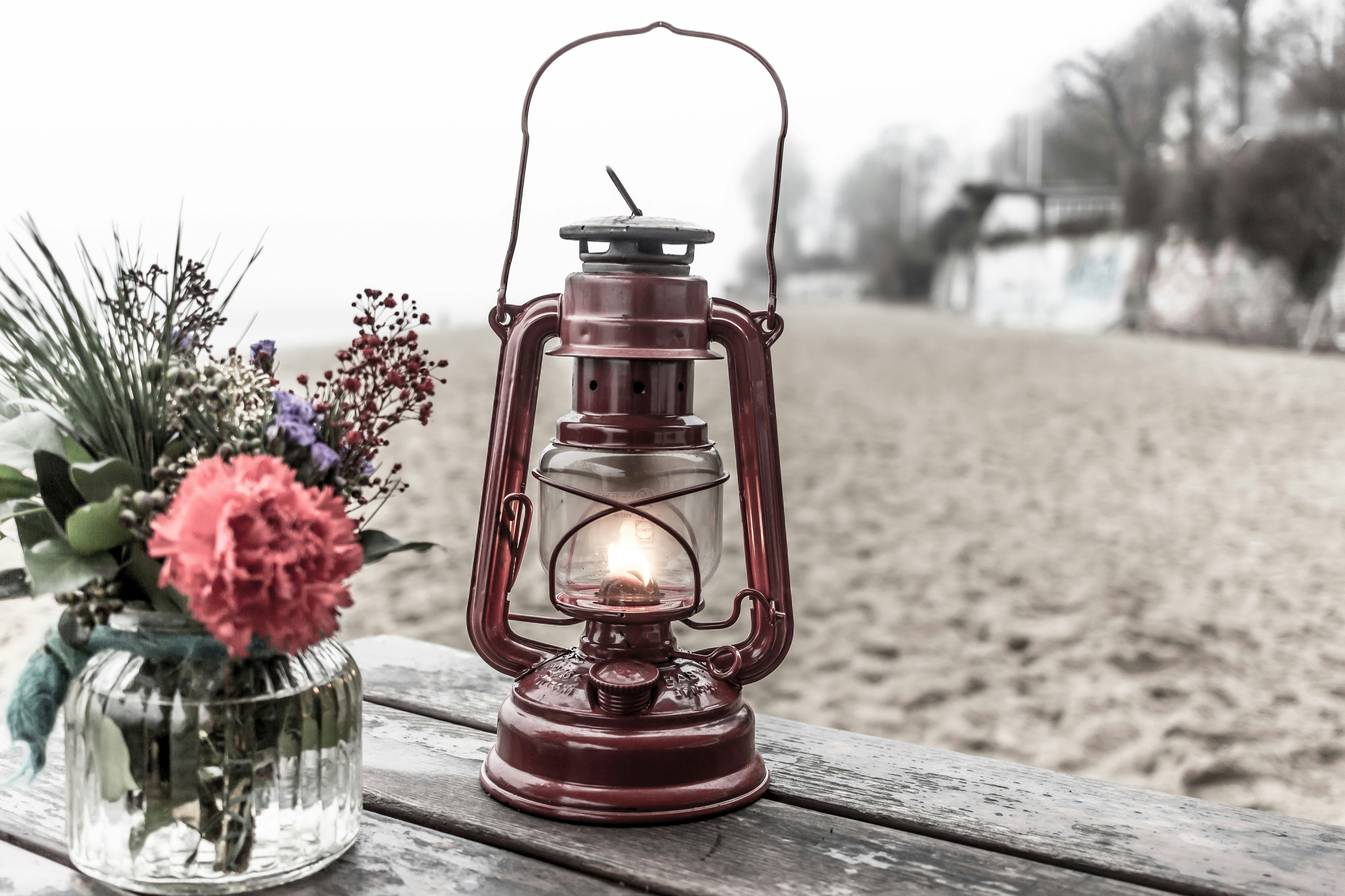 Lone Lantern on Weathered Wood: Quiet Beachside Still Life