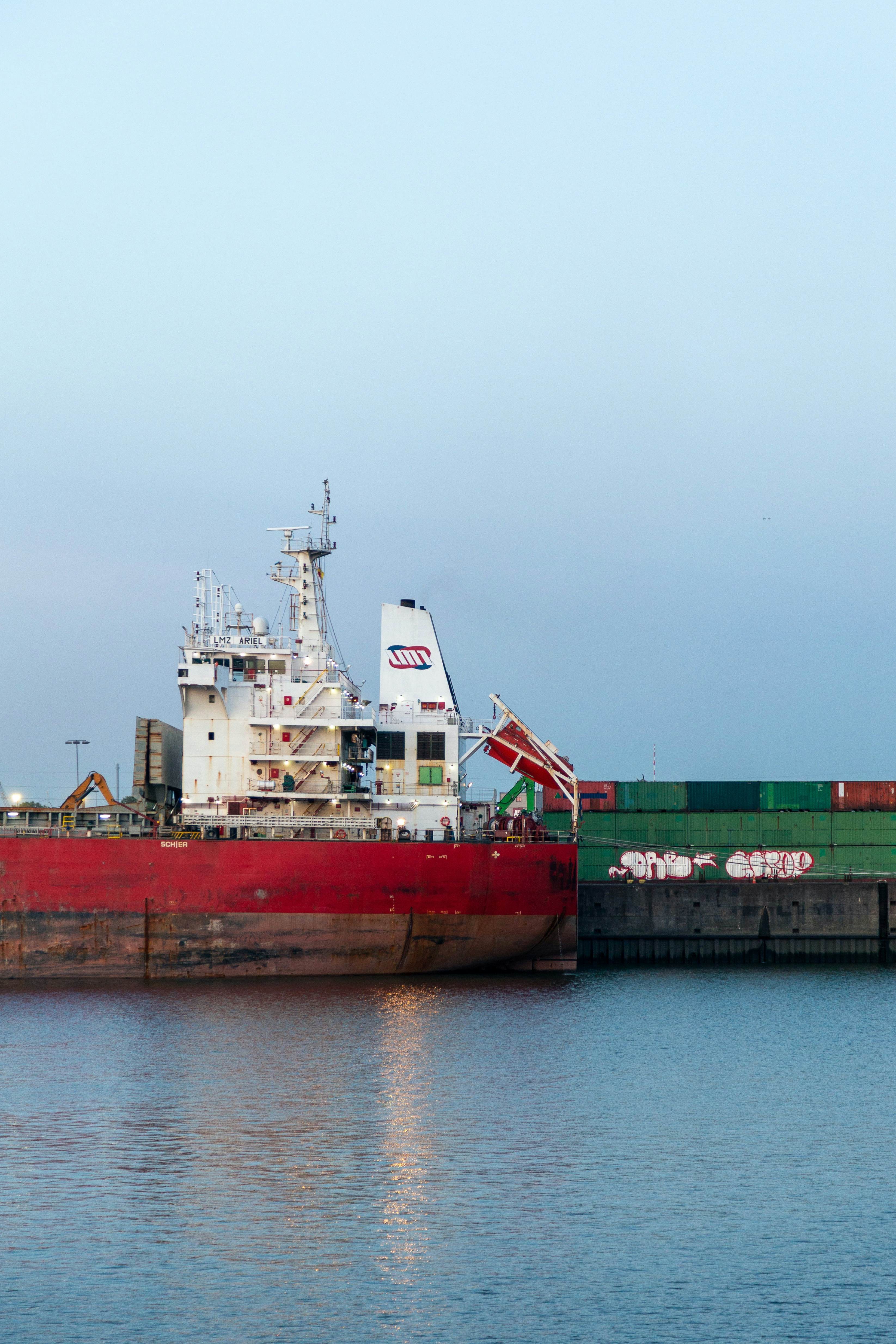 Harbor Giant: A Red Hull Framing the Calm Waterfront