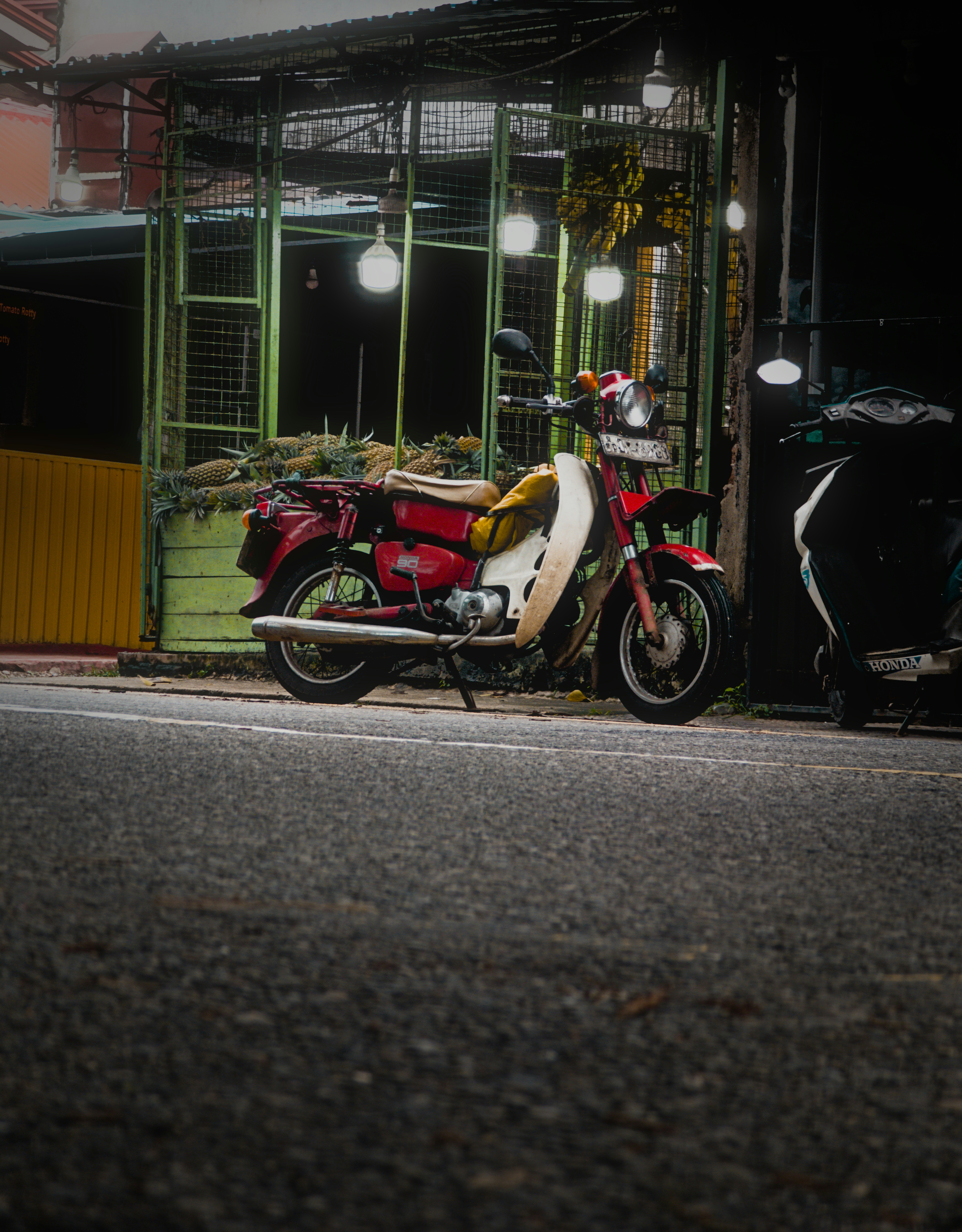 Urban Red Scooter Under Neon Gatelight